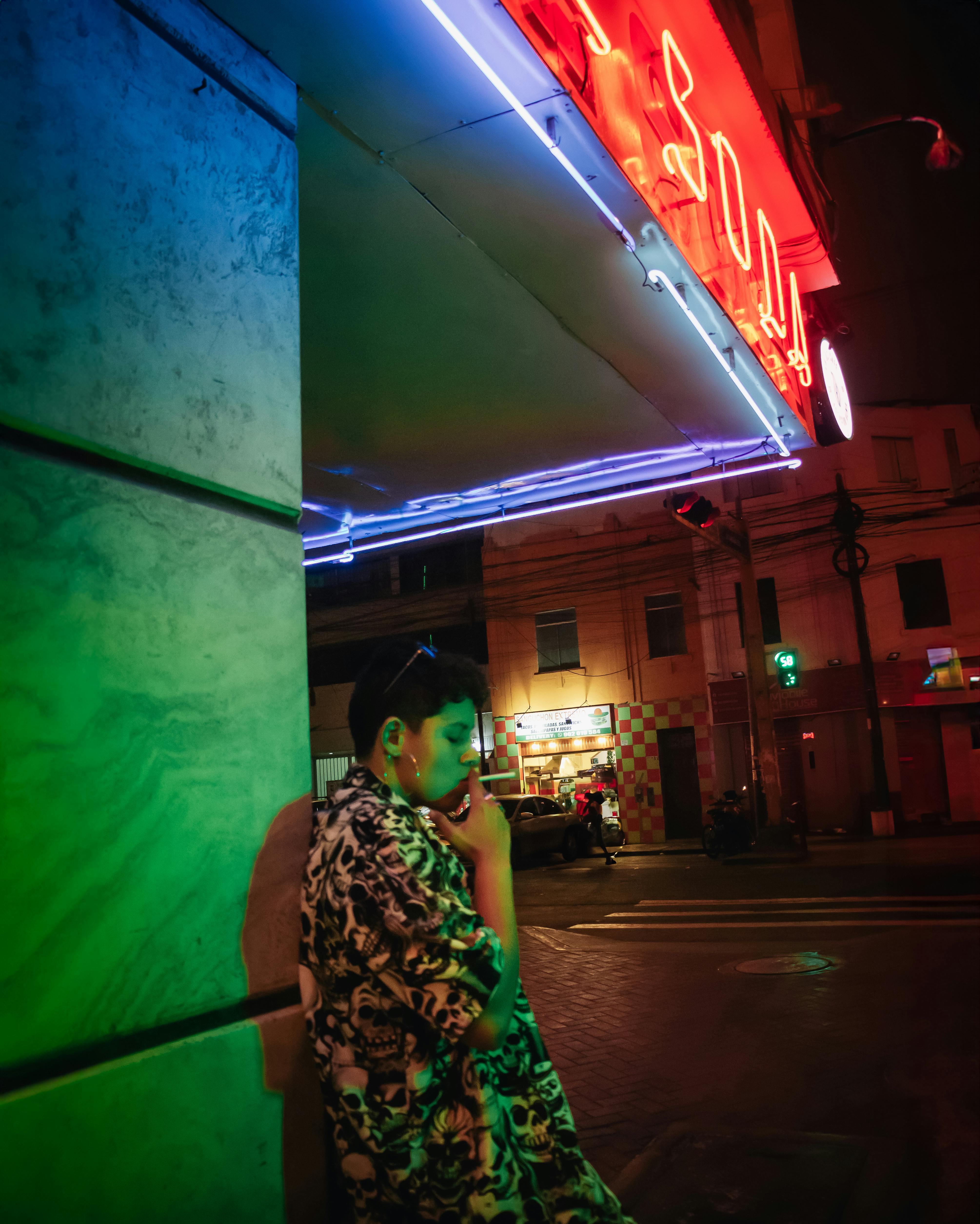 Black guy in street near building with glowing signboard · Free Stock Photo