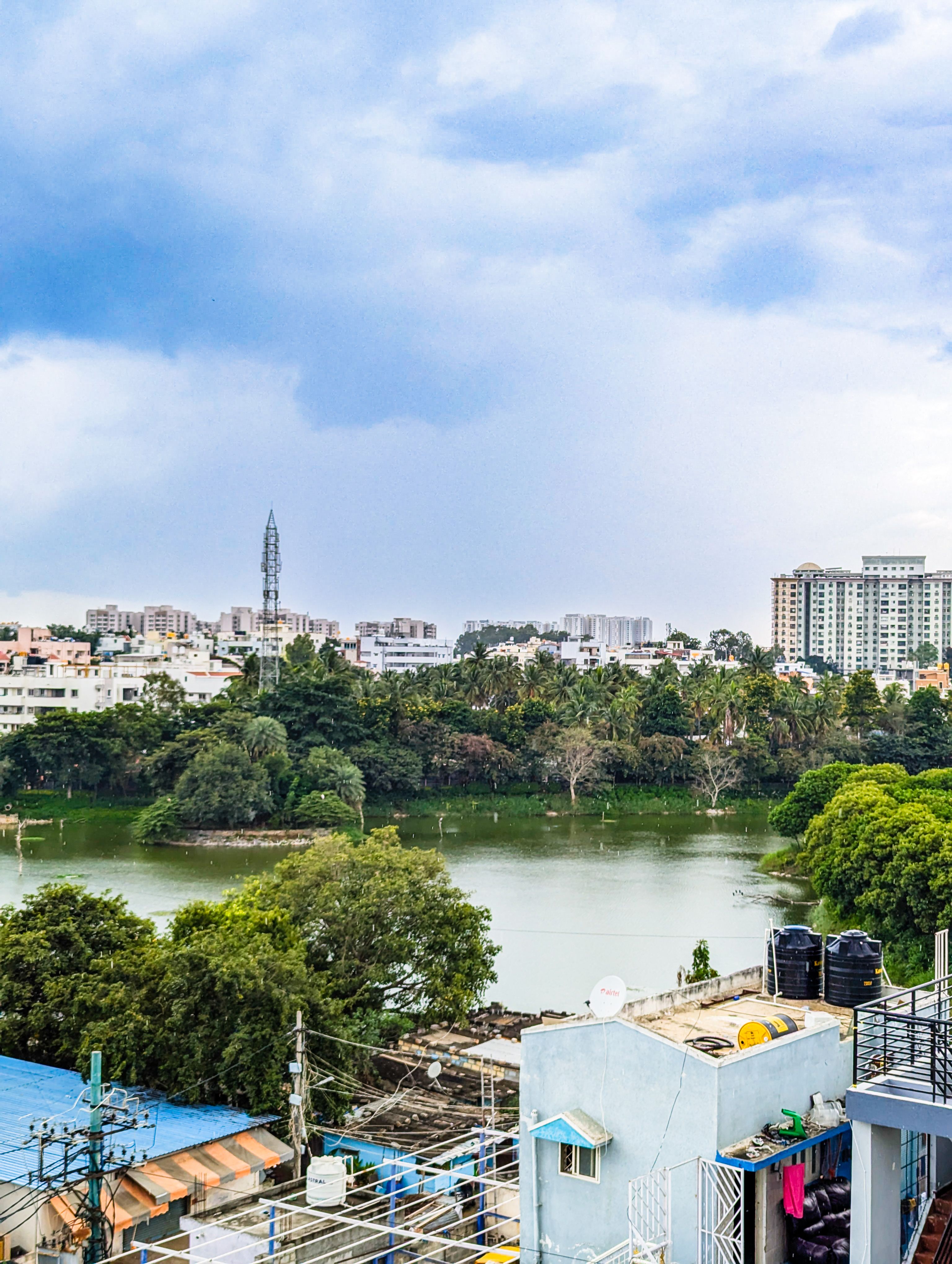 Scenic Urban Lake View with Cloudy Sky · Free Stock Photo