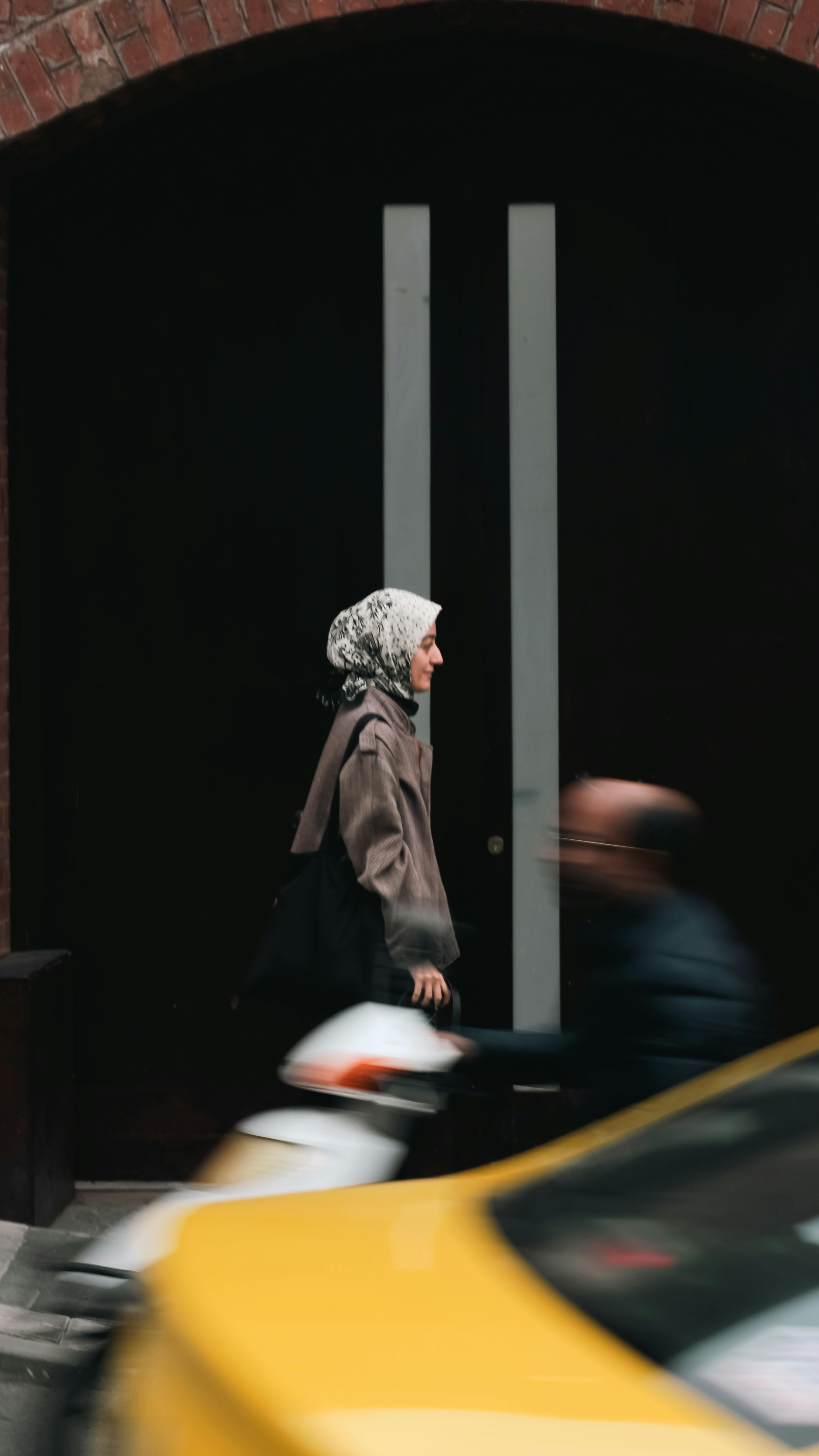 Street Scene with Woman in Hijab Blurred Taxi · Free Stock Photo