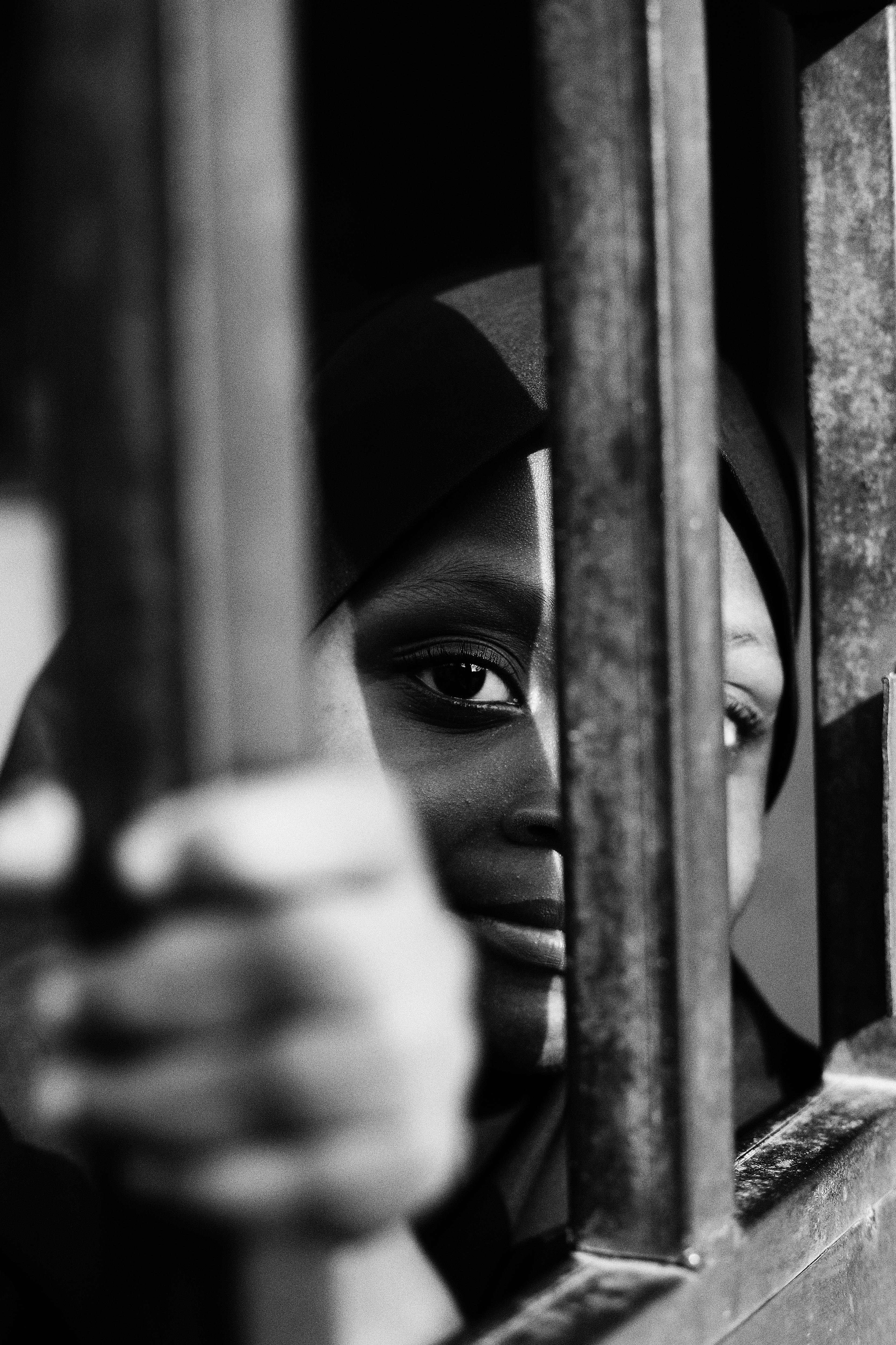 Thoughtful Portrait of a Child Behind Bars · Free Stock Photo