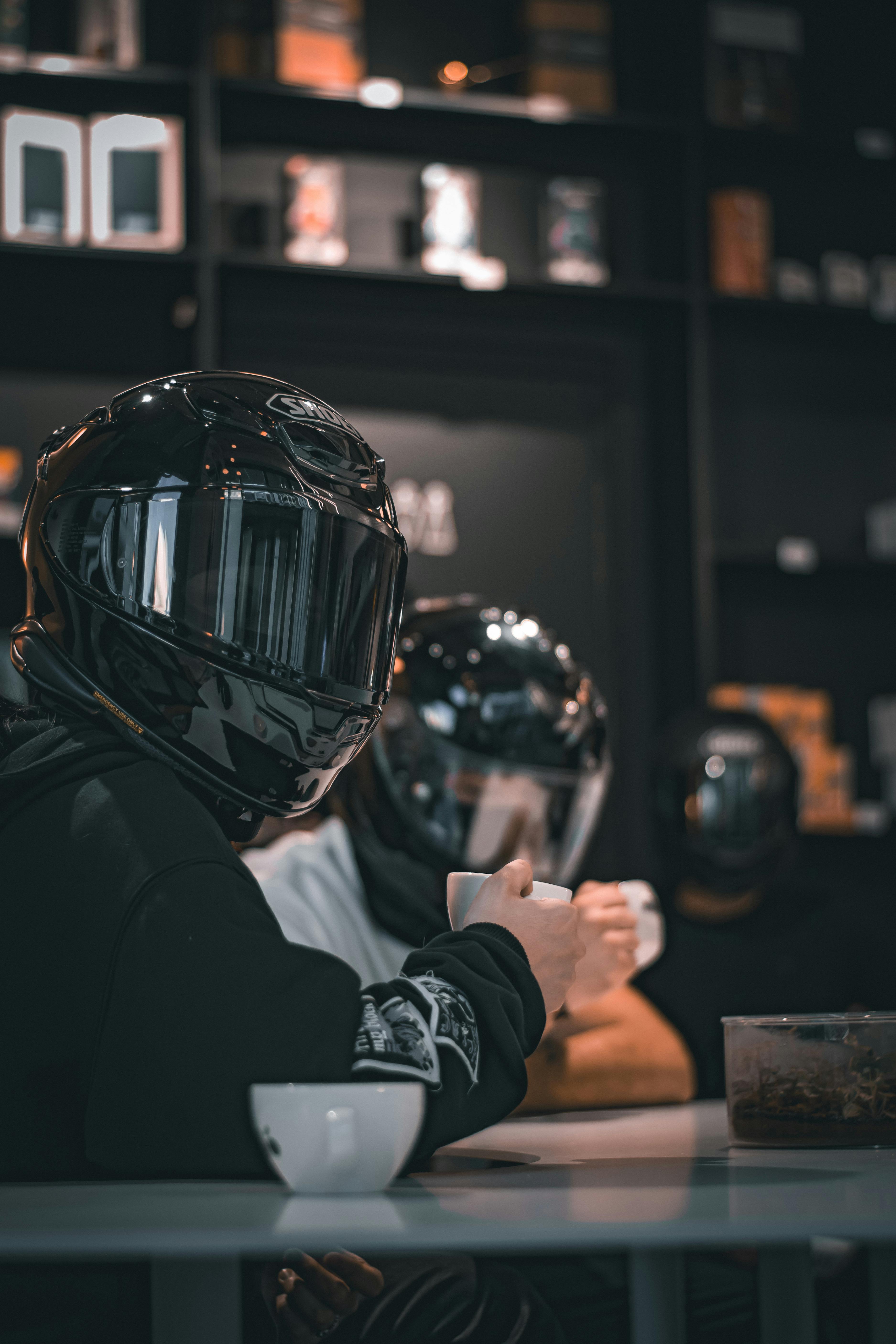Motorcyclists Wearing Helmets in Cafe Setting · Free Stock Photo
