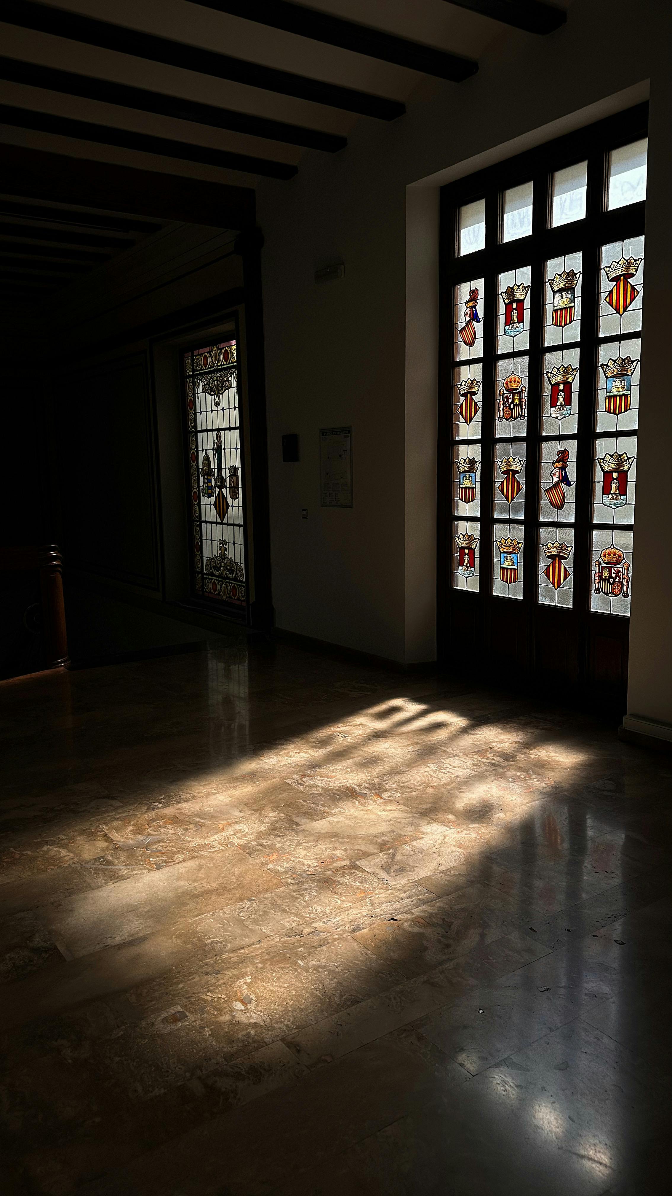 Sunlight Through Stained Glass in Historic Hallway · Free Stock Photo