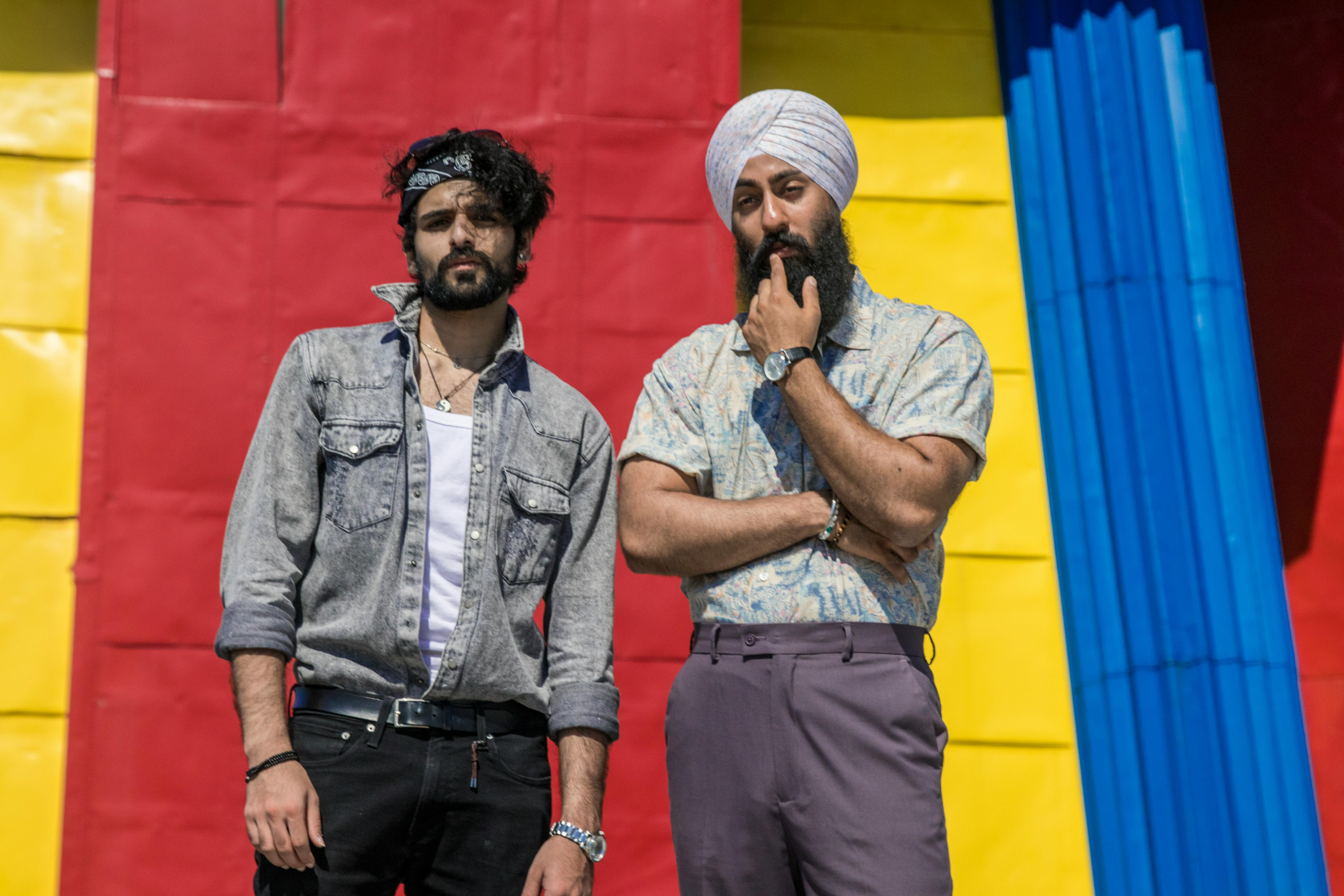 Two Men Standing Beside A Colorful Wall · Free Stock Photo