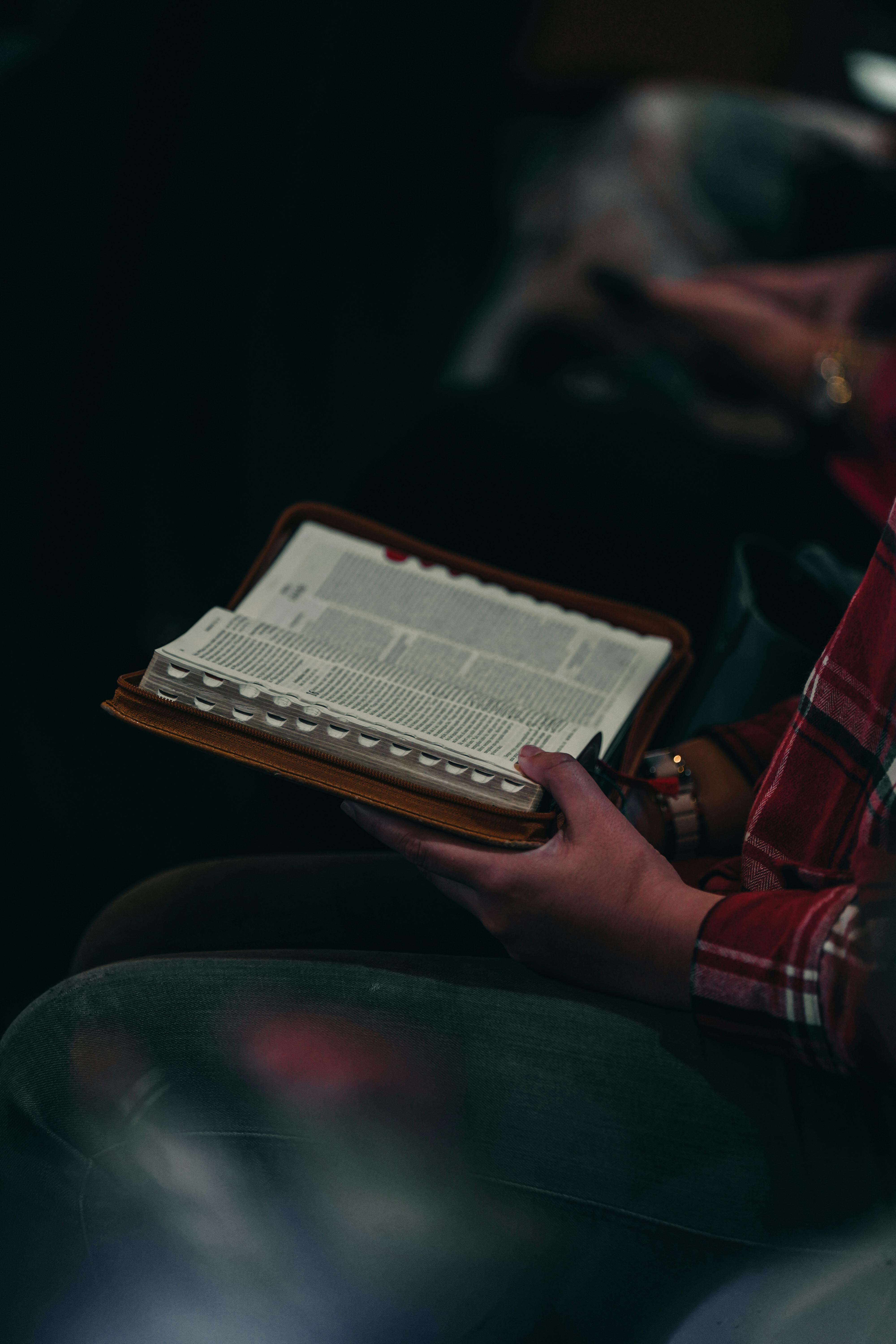 Person Holding Open Bible During Reading · Free Stock Photo