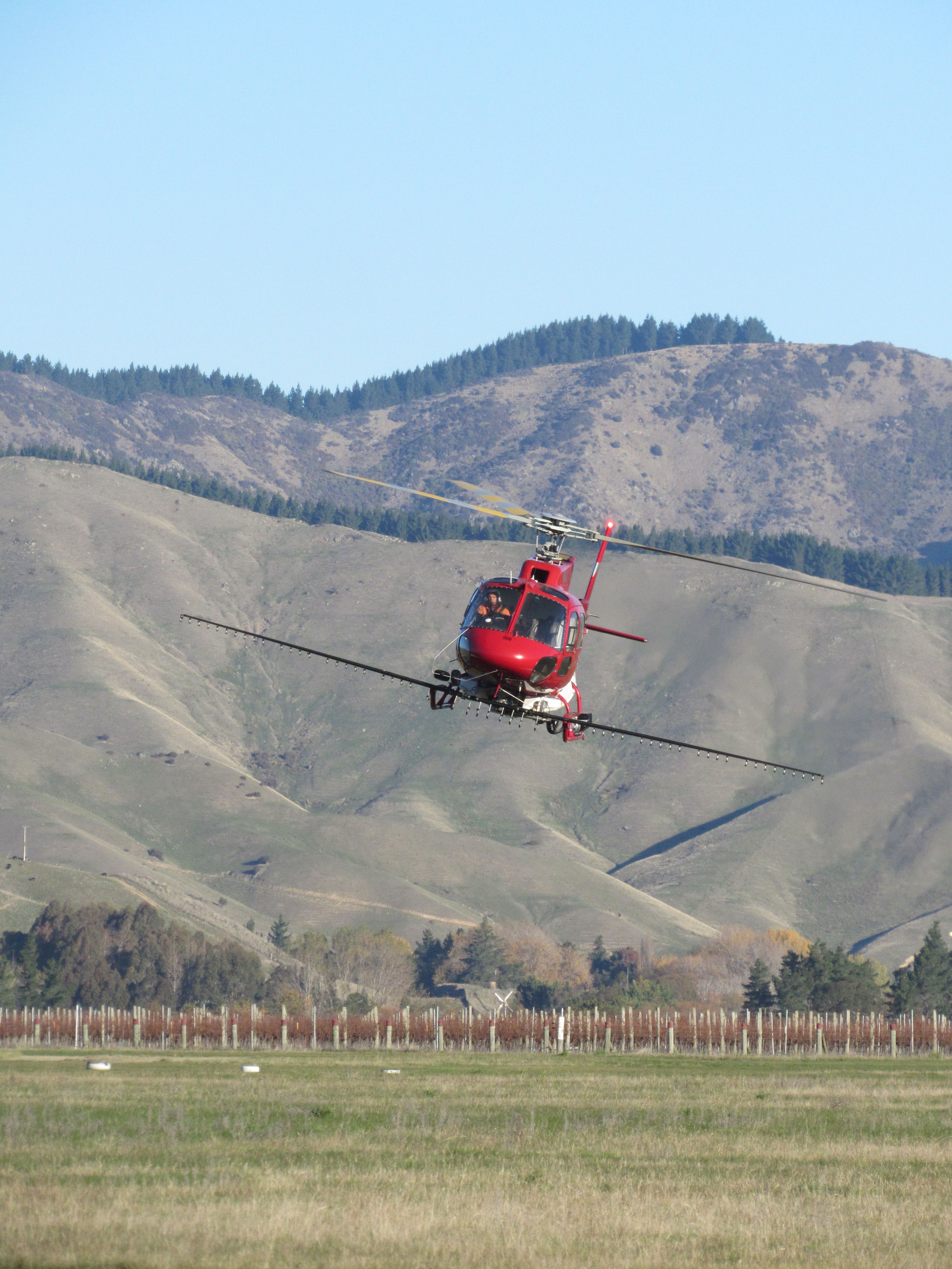 Red Helicopter Flying Over Mountainous Landscape · Free Stock Photo
