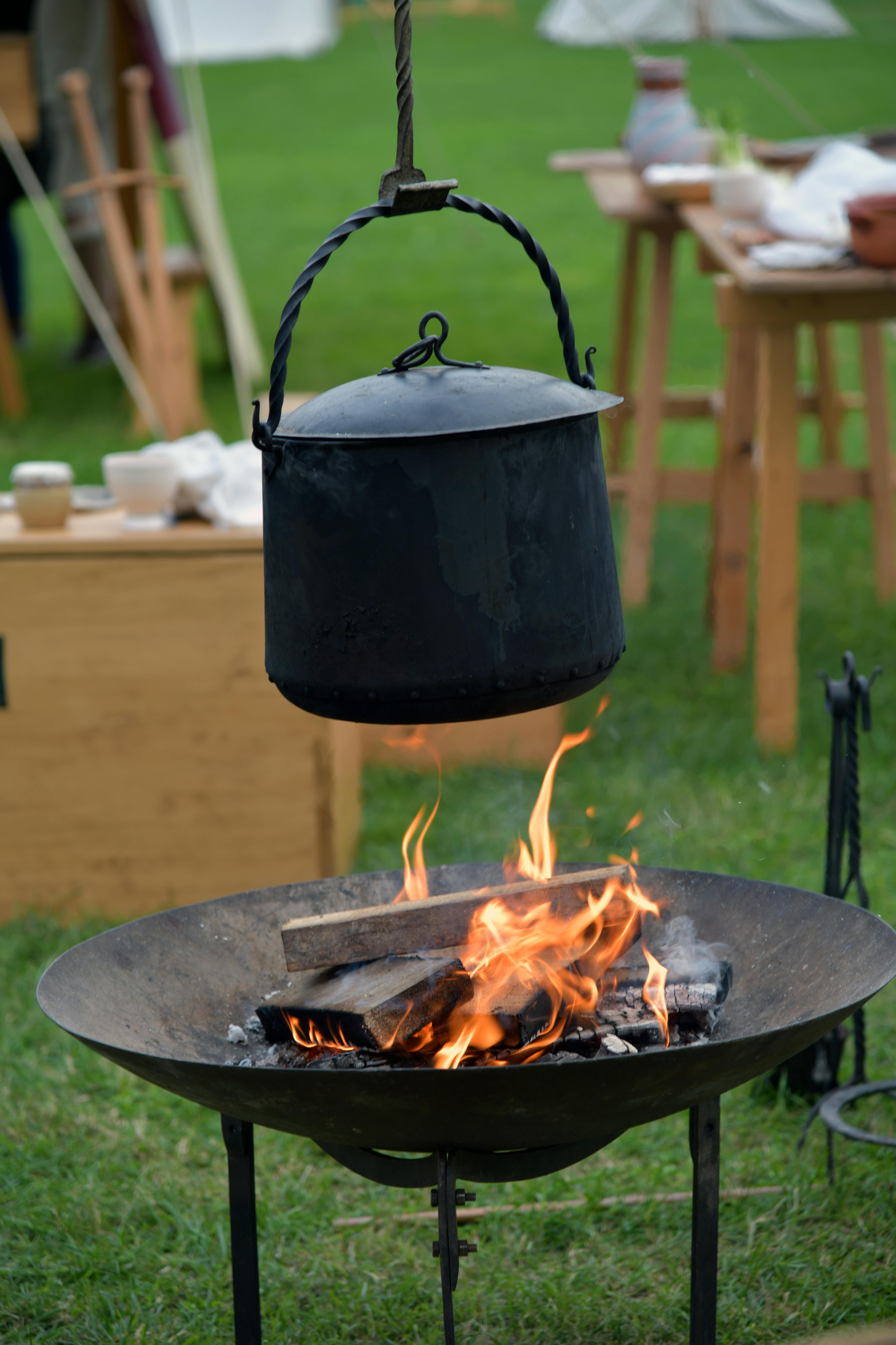 Vintage outdoor cooking setup with iron pot over fire · Free Stock Photo
