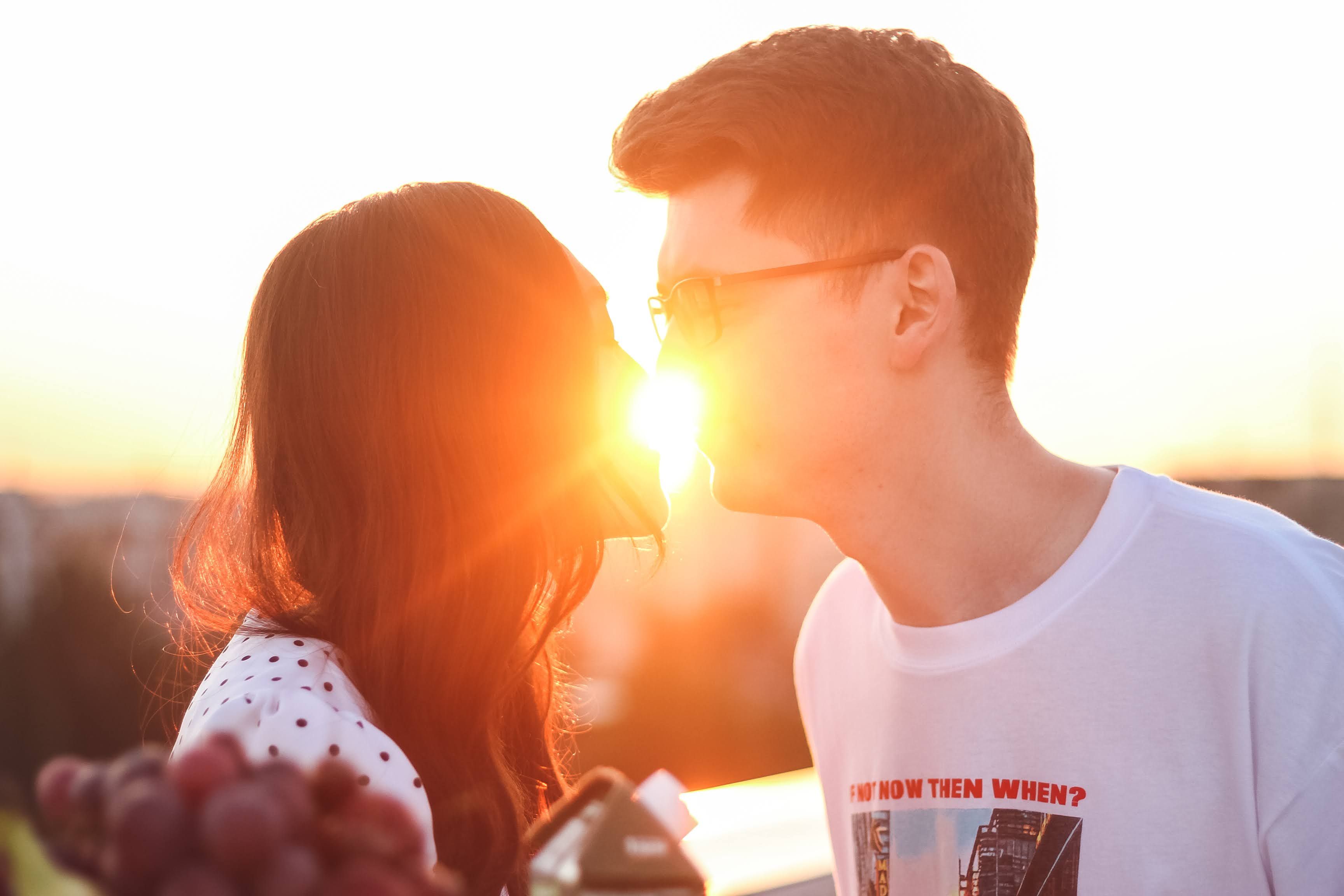 Romantic Sunset Kiss Captured in Warm Light · Free Stock Photo