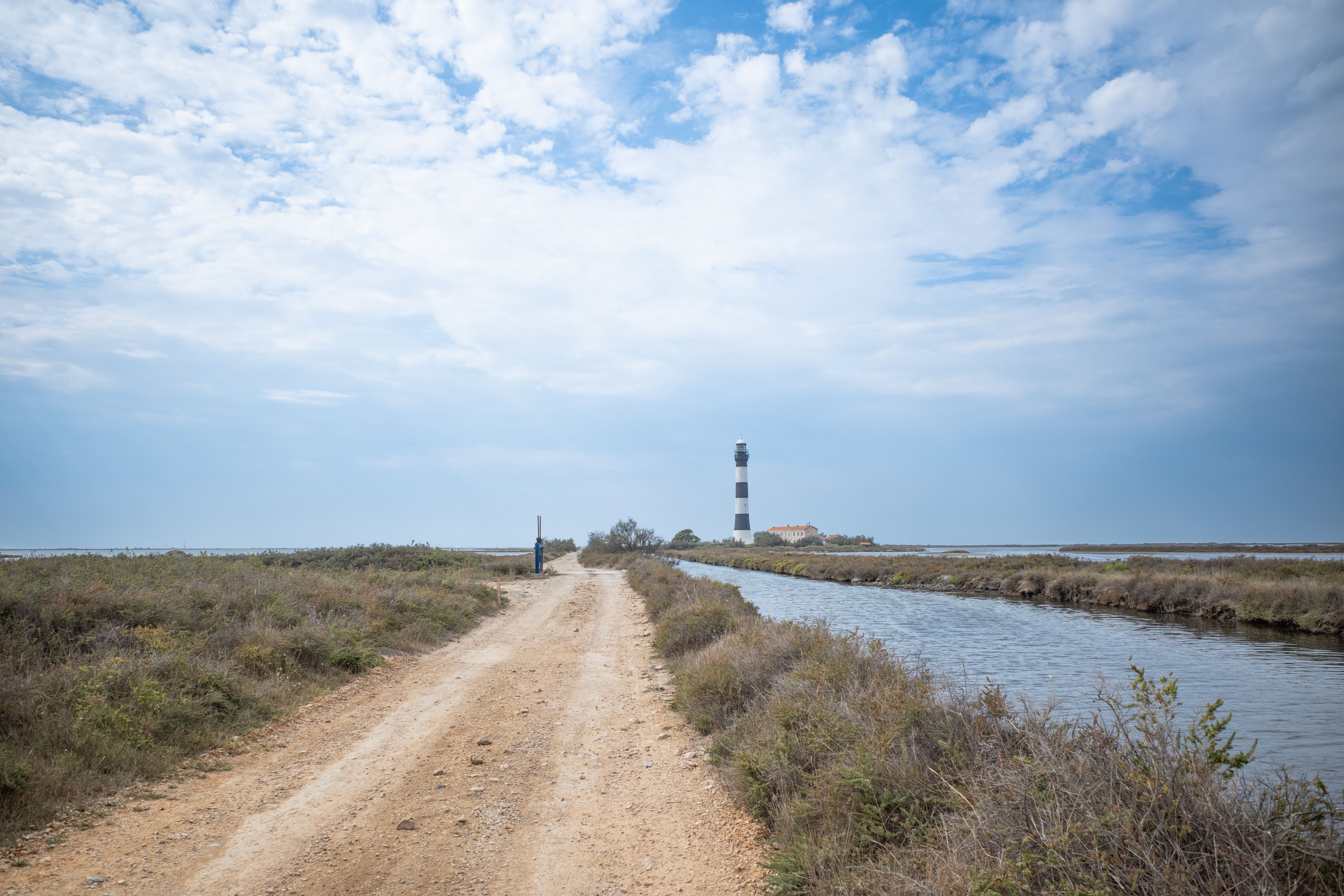Scenic Coastal Lighthouse and Dirt Road Panorama · Free Stock Photo