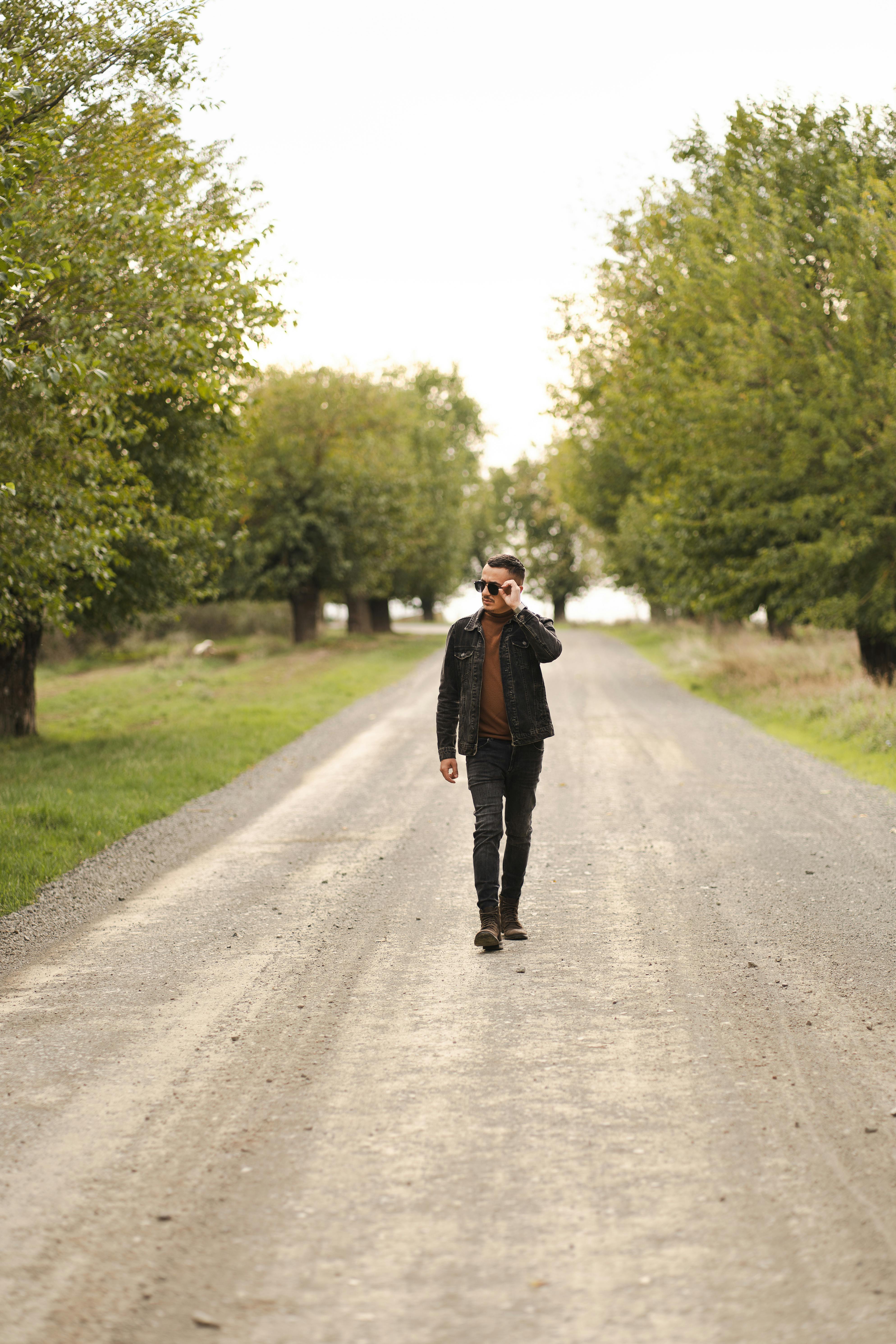 Man Walking on Rural Road in Fall Scenery · Free Stock Photo