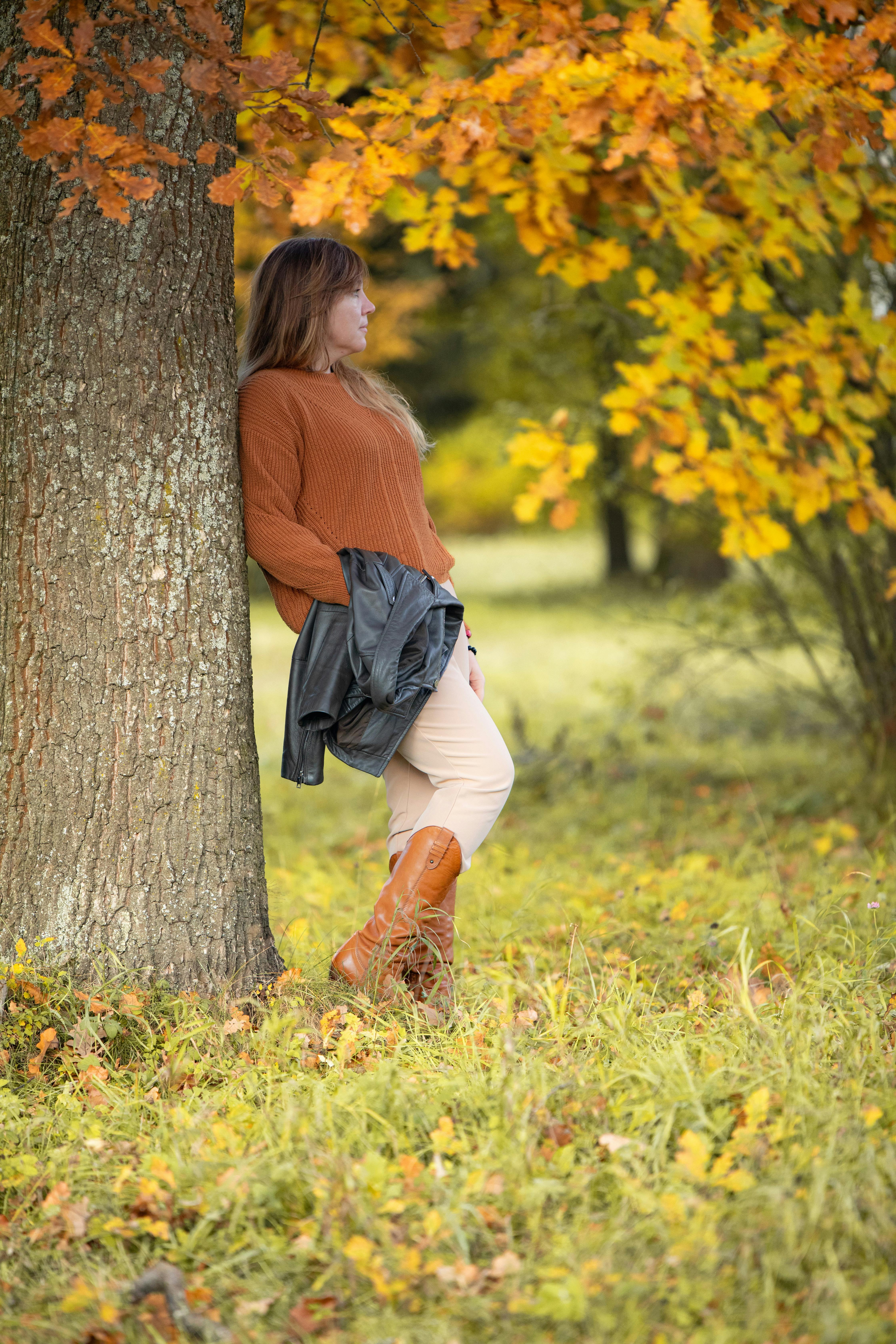 Woman in Fall Fashion Leaning on Tree Outdoors · Free Stock Photo