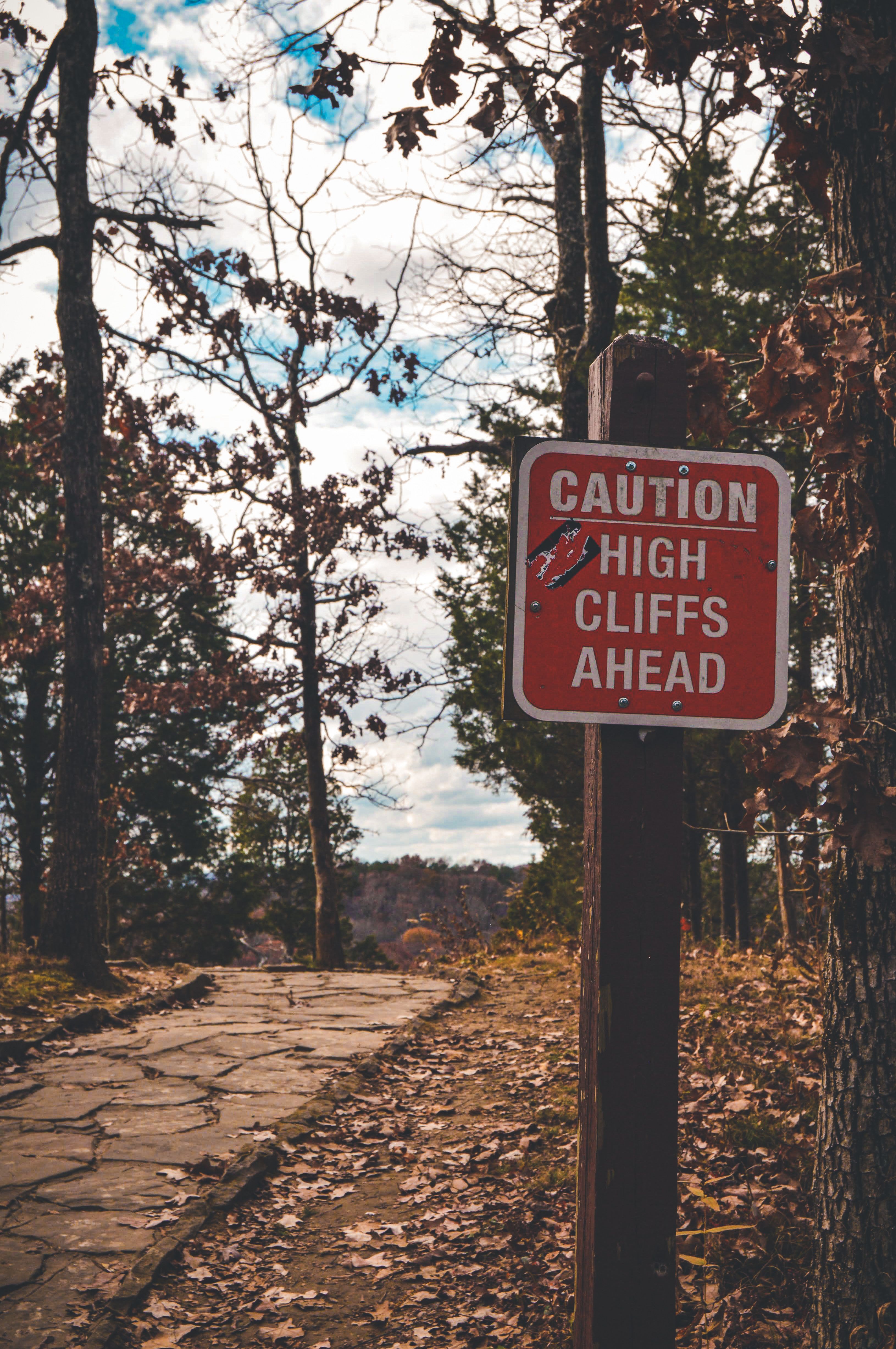 Caution Sign on Scenic Forest Trail in Fall · Free Stock Photo