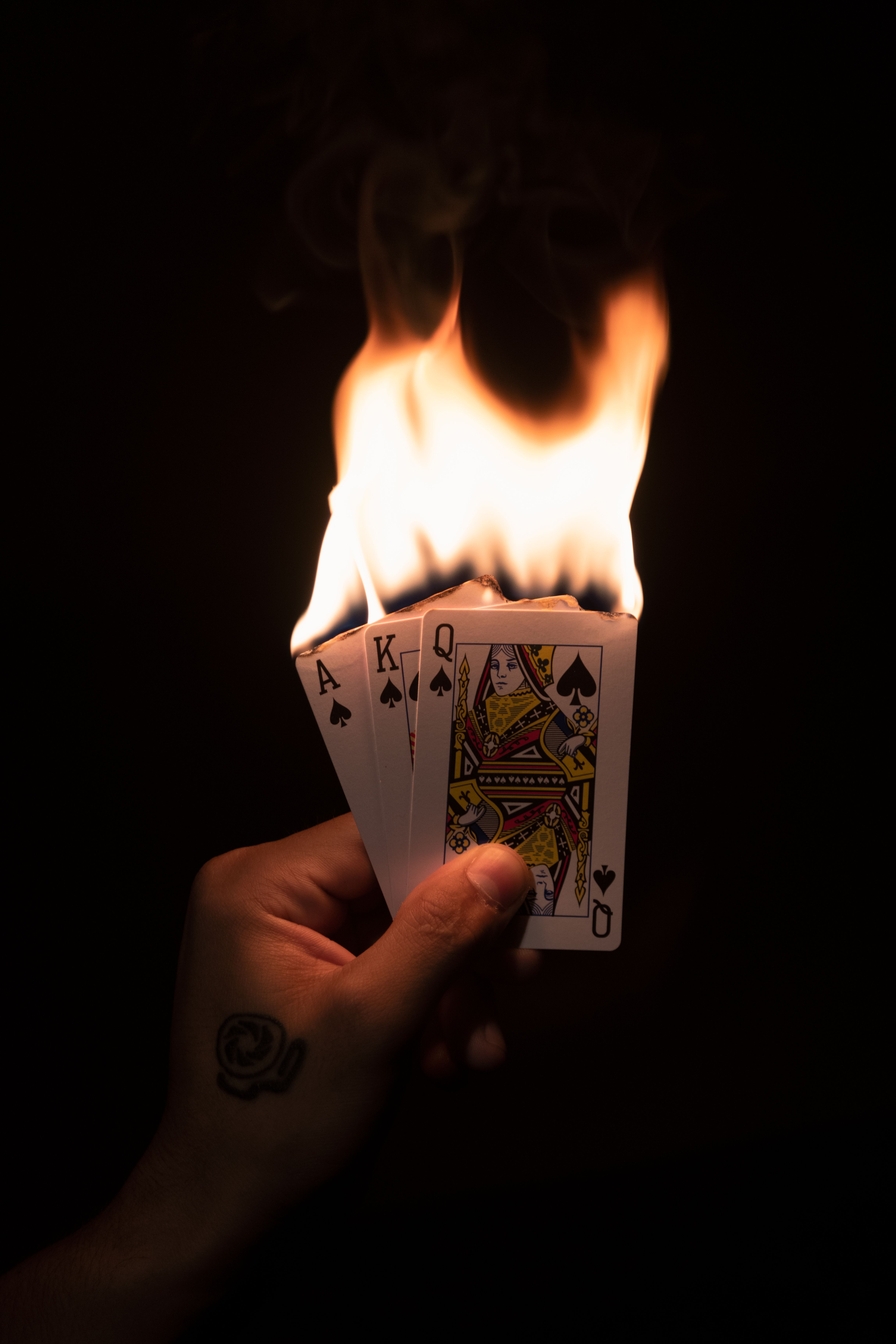 Burning Playing Cards in Hand with Tattoo · Free Stock Photo