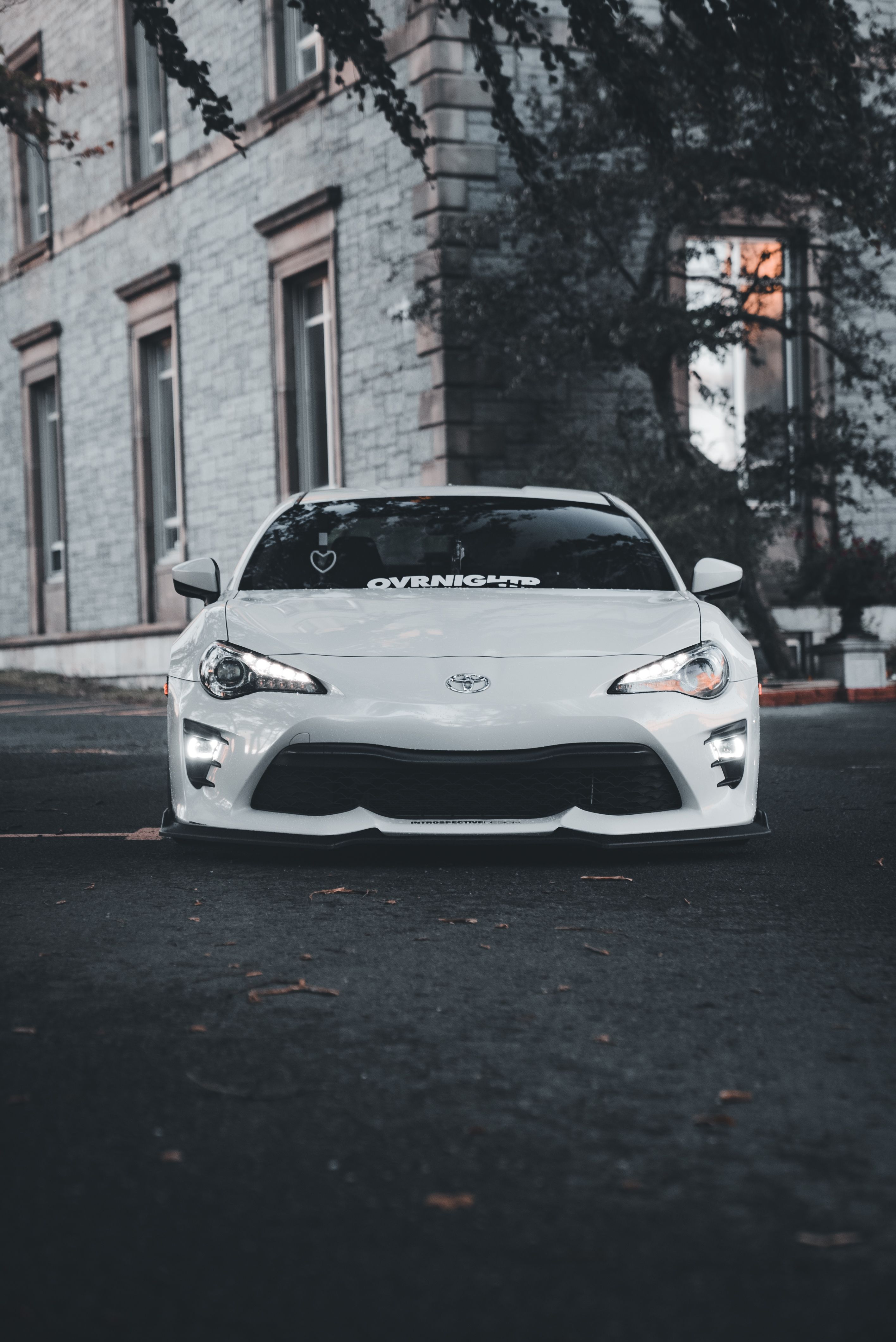 Elegant White Car Parked by Historic Building · Free Stock Photo