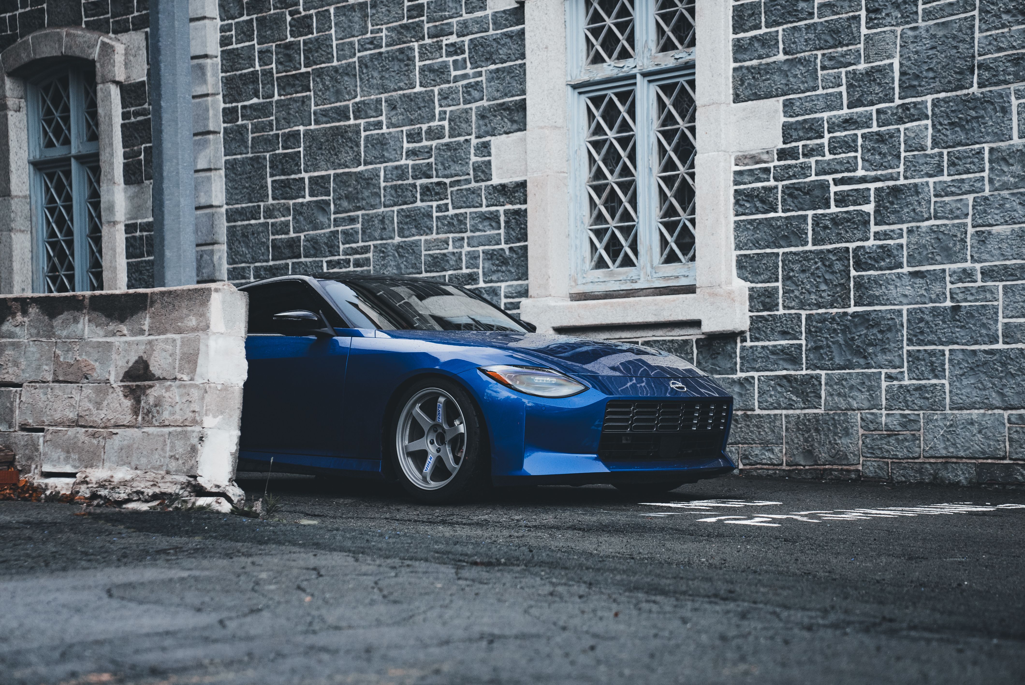 Sleek Blue Sports Car by Historic Stone Building · Free Stock Photo