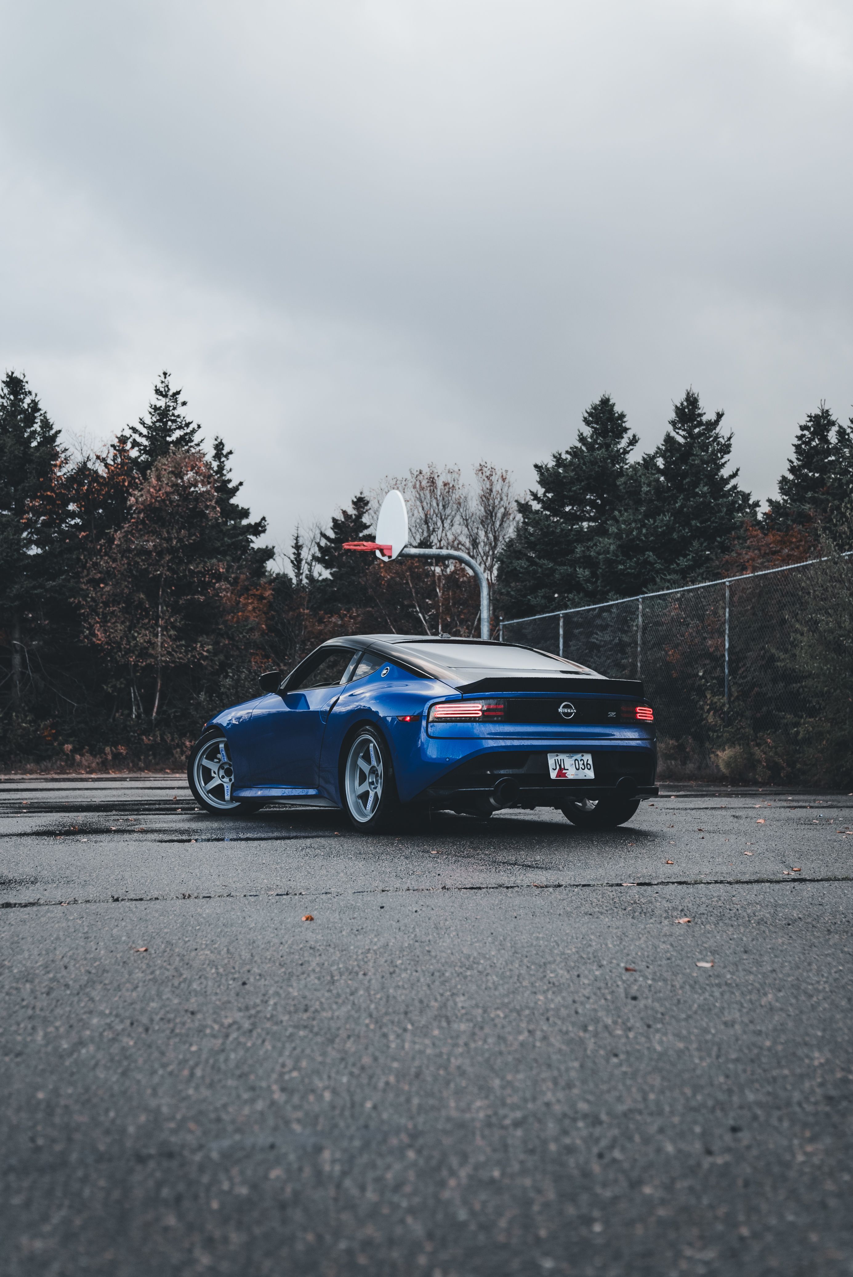 Sleek Blue Sports Car in Outdoor Basketball Court · Free Stock Photo