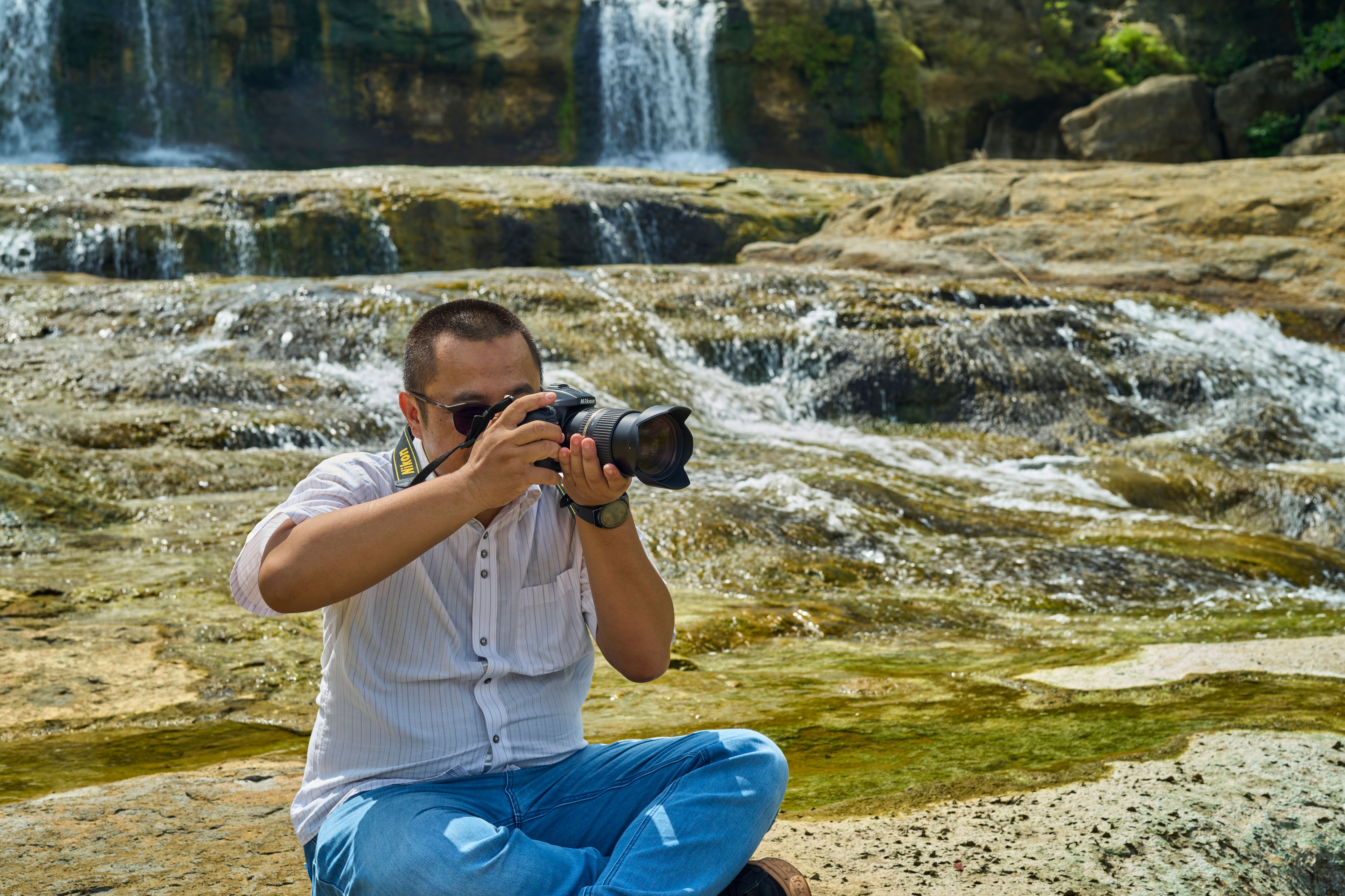 Photographer Capturing Waterfall Scenery · Free Stock Photo