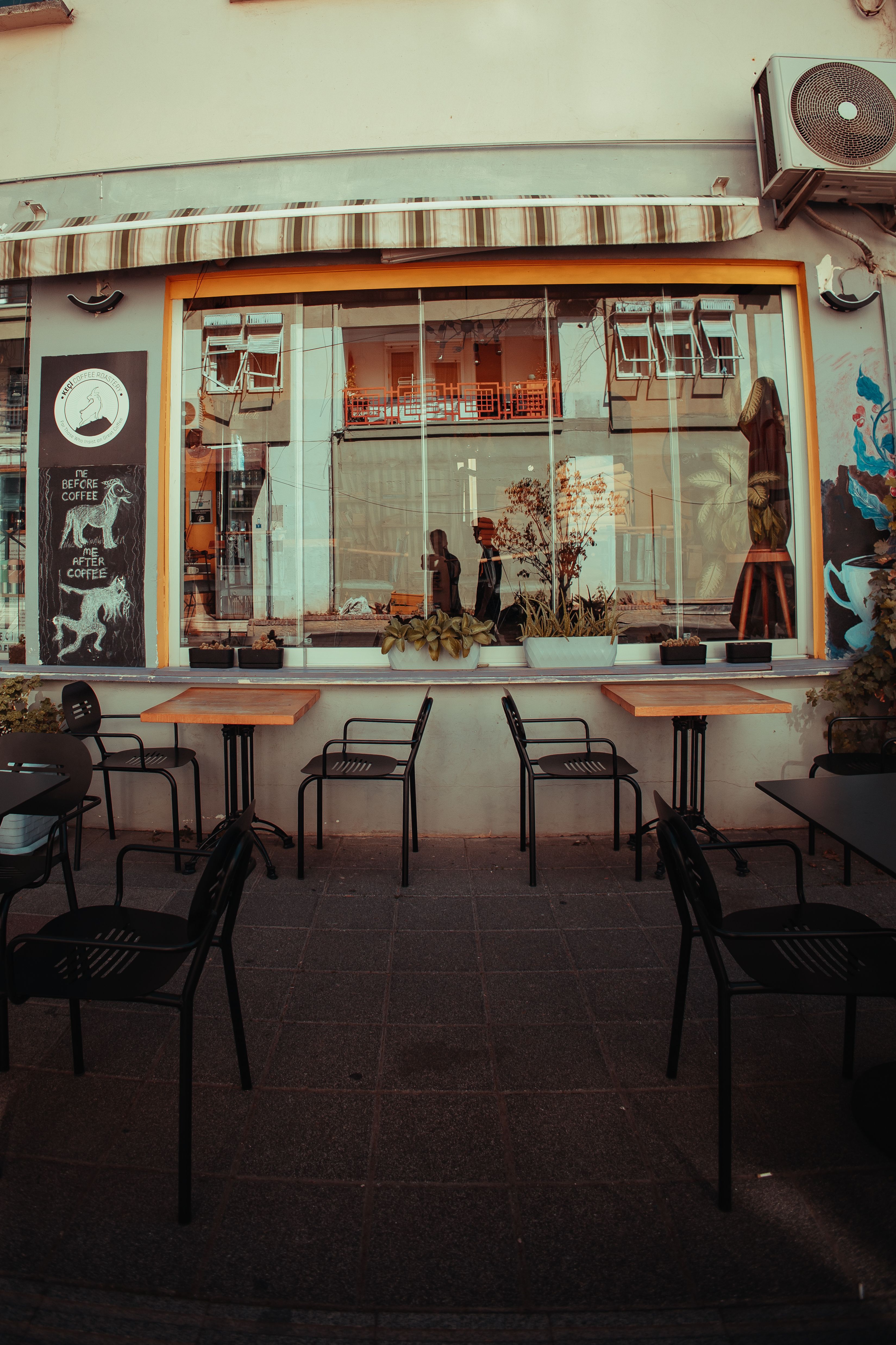Cozy Outdoor Café Seating with Window View · Free Stock Photo