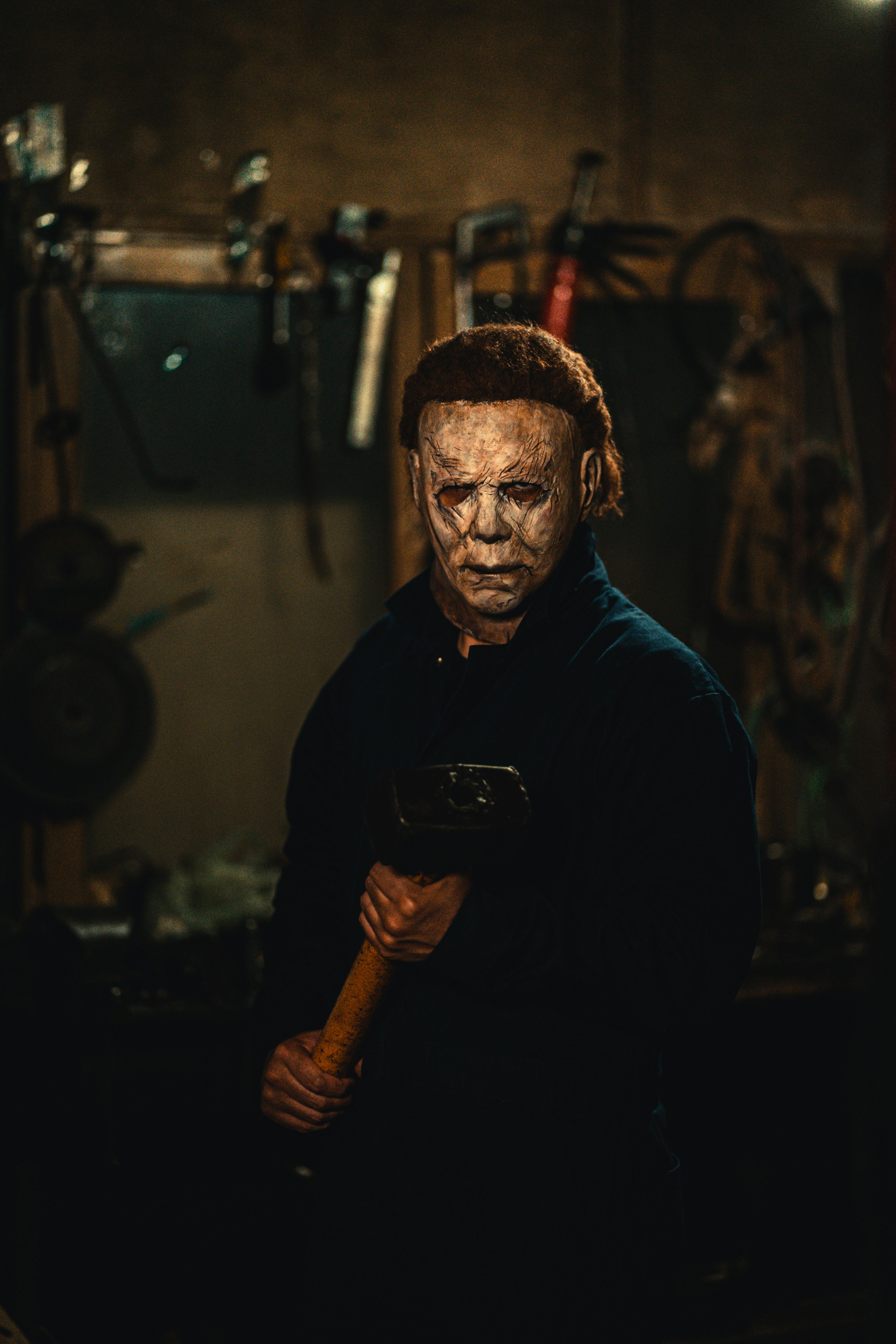 Halloween Masked Figure in Dimly Lit Workshop · Free Stock Photo