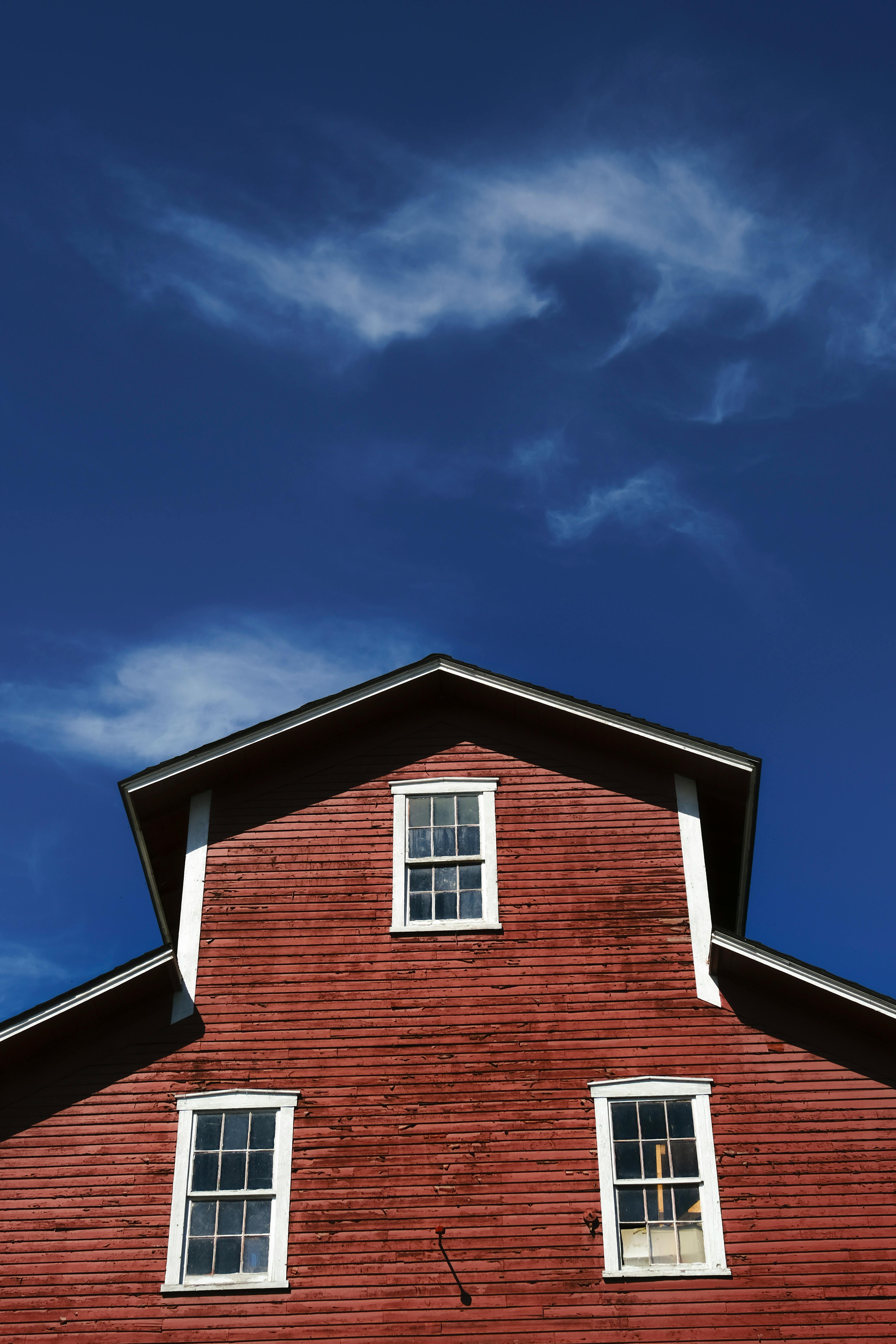 Red Barn Roof Against Clear Blue Sky · Free Stock Photo