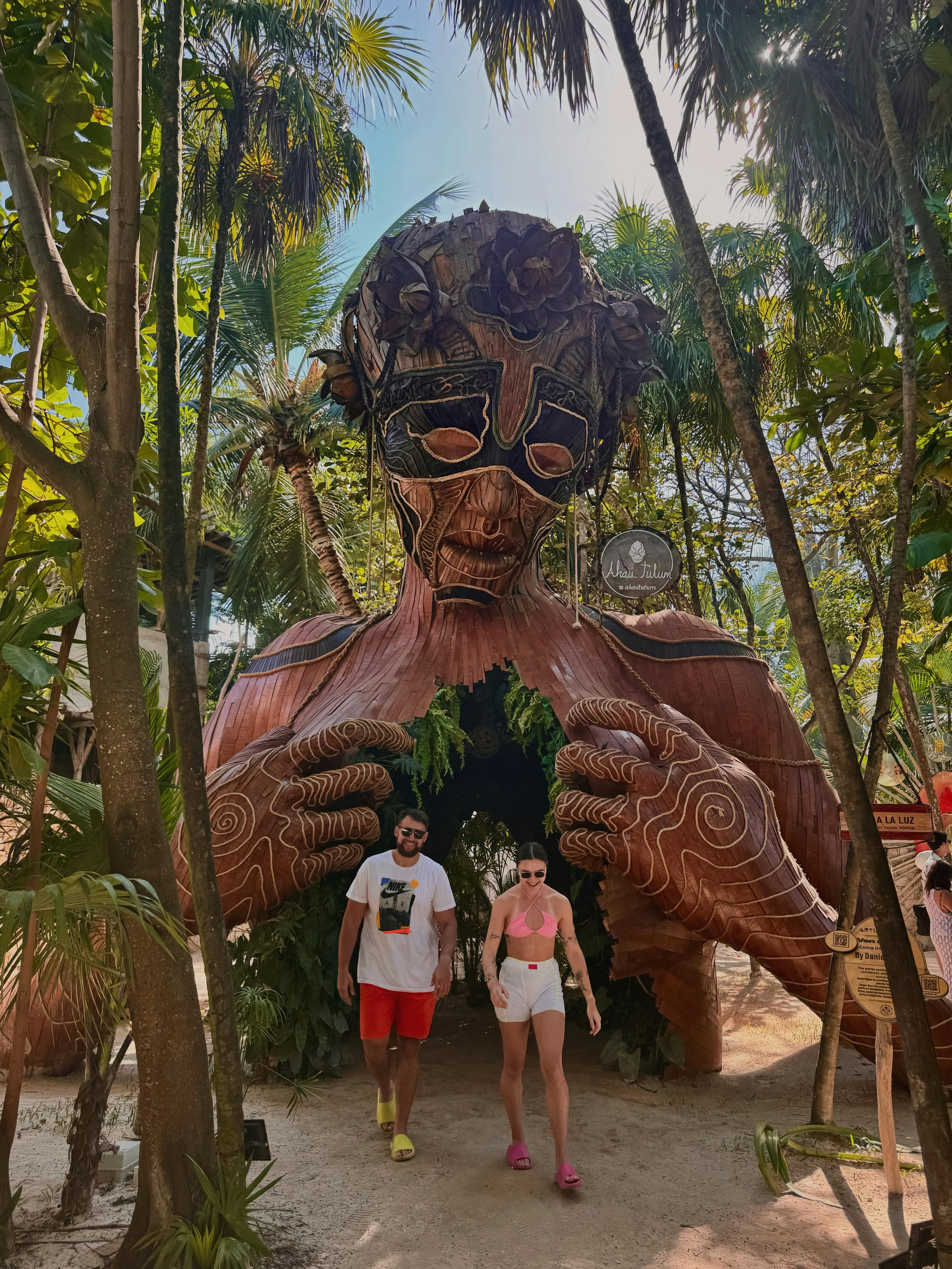 Tourists Exploring Famous Tulum Wooden Sculpture · Free Stock Photo