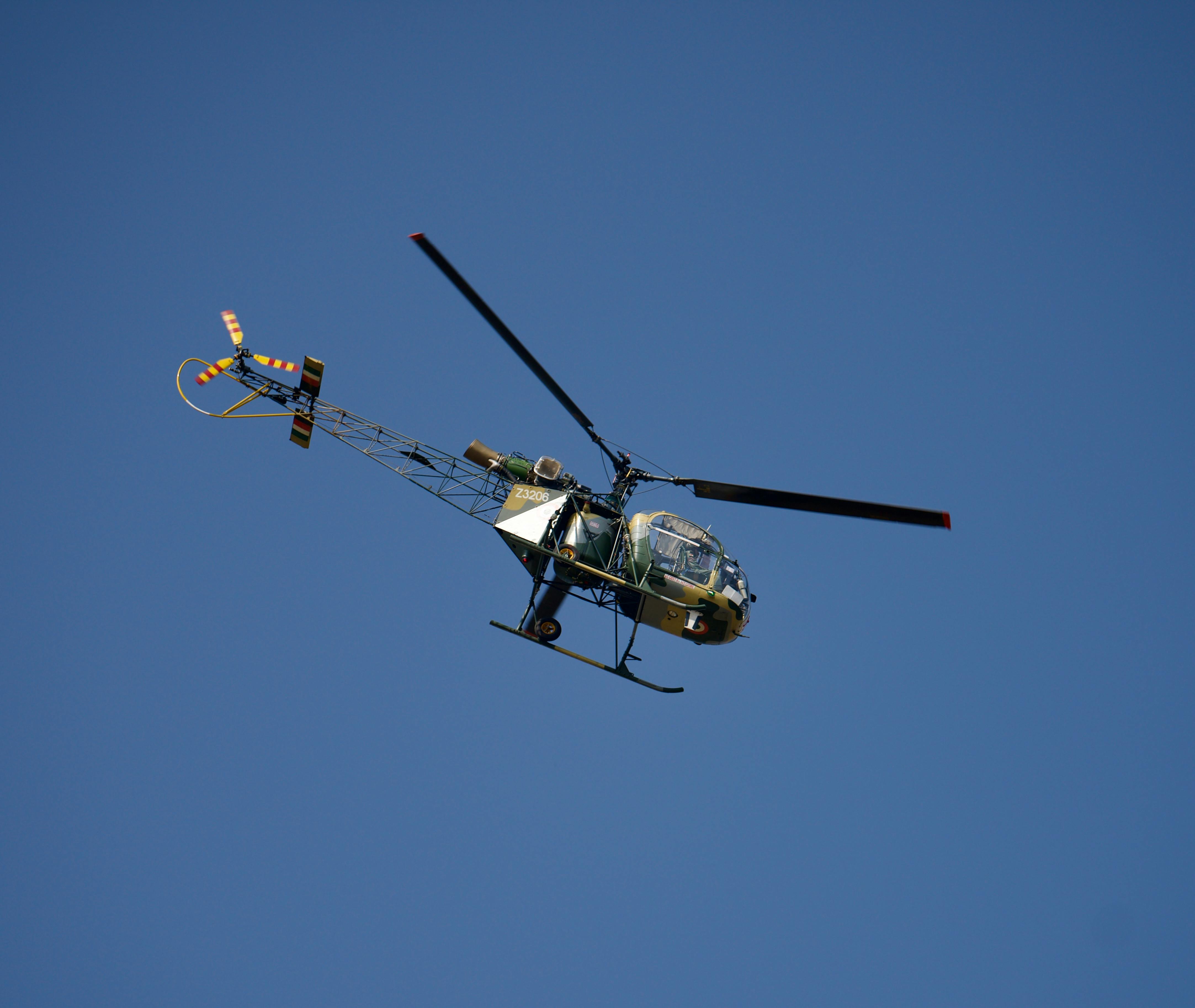 Vintage Helicopter in Mid-Air Against Clear Blue Sky · Free Stock Photo