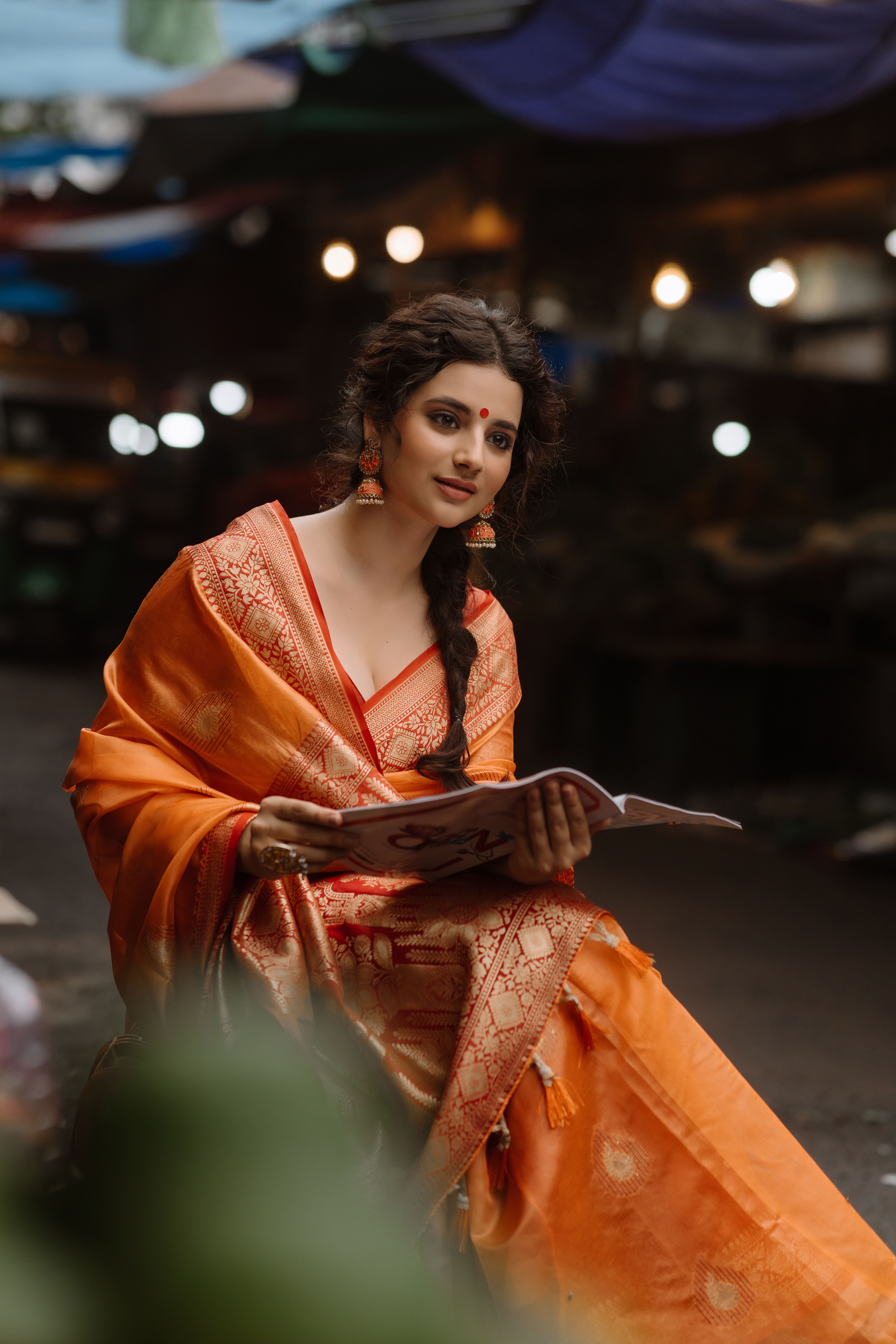 Elegant Woman in Traditional Saree Reading · Free Stock Photo