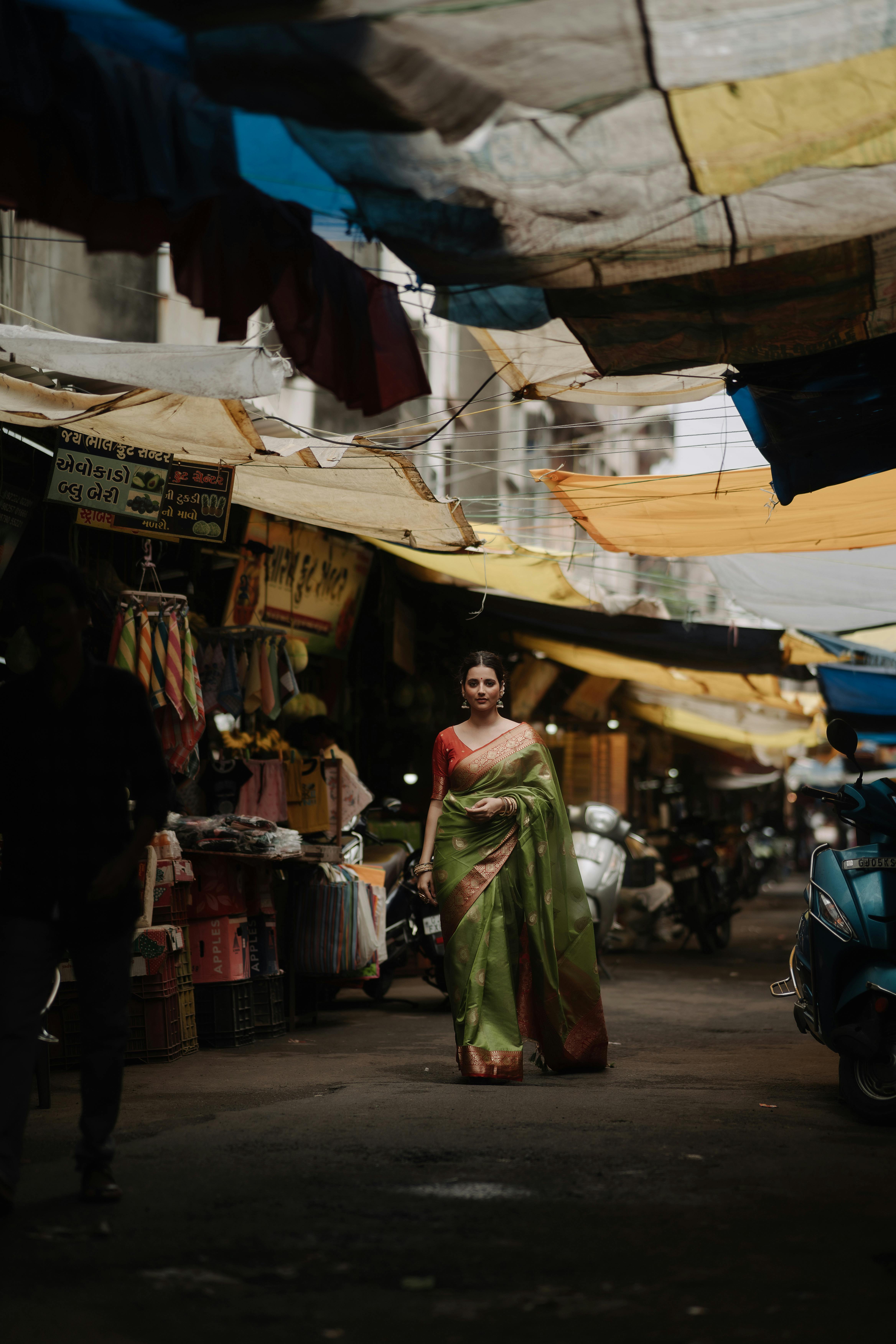 Woman in Saree Walking Through Vibrant Market · Free Stock Photo