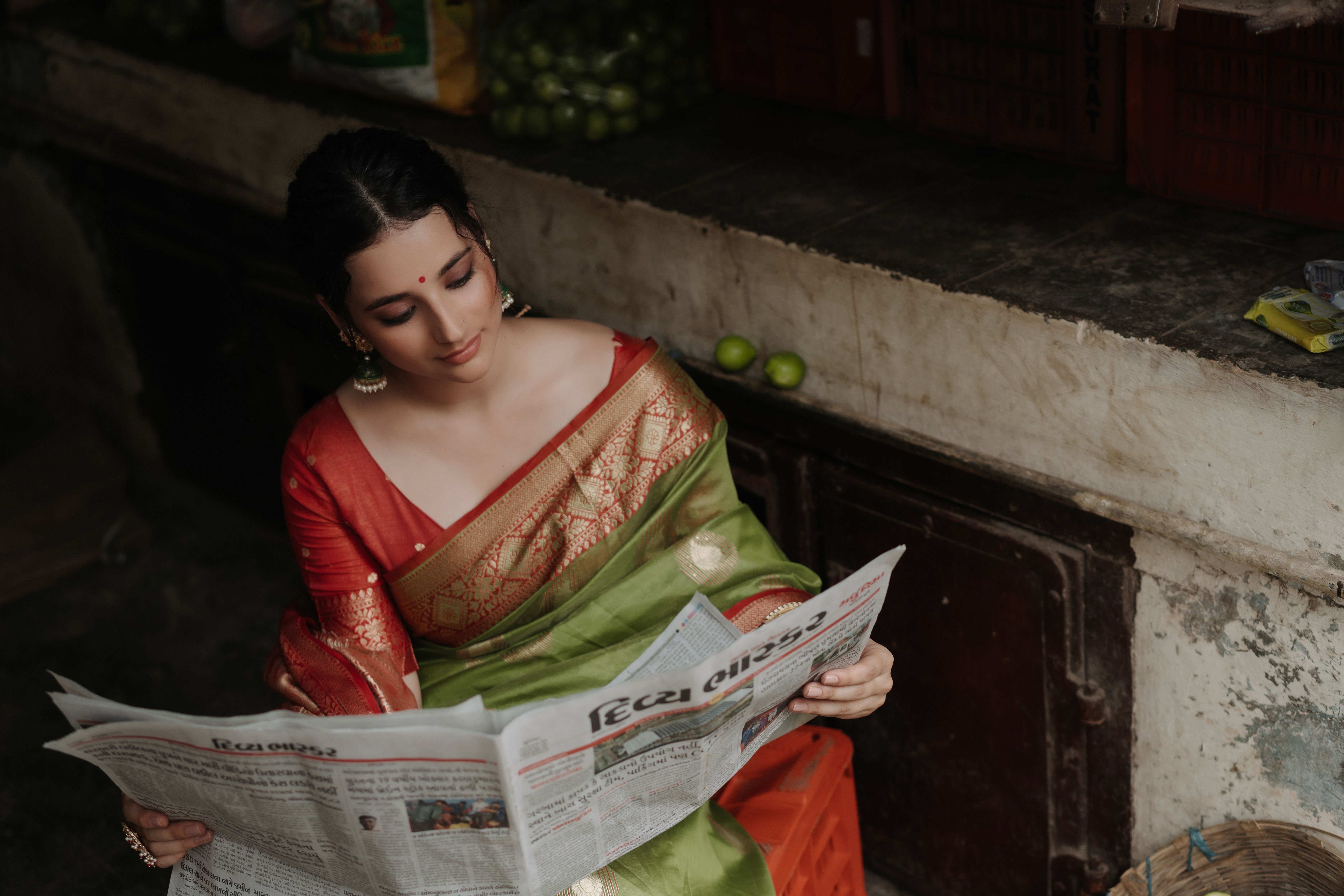 Woman in Traditional Saree Reading Newspaper Indoors · Free Stock Photo