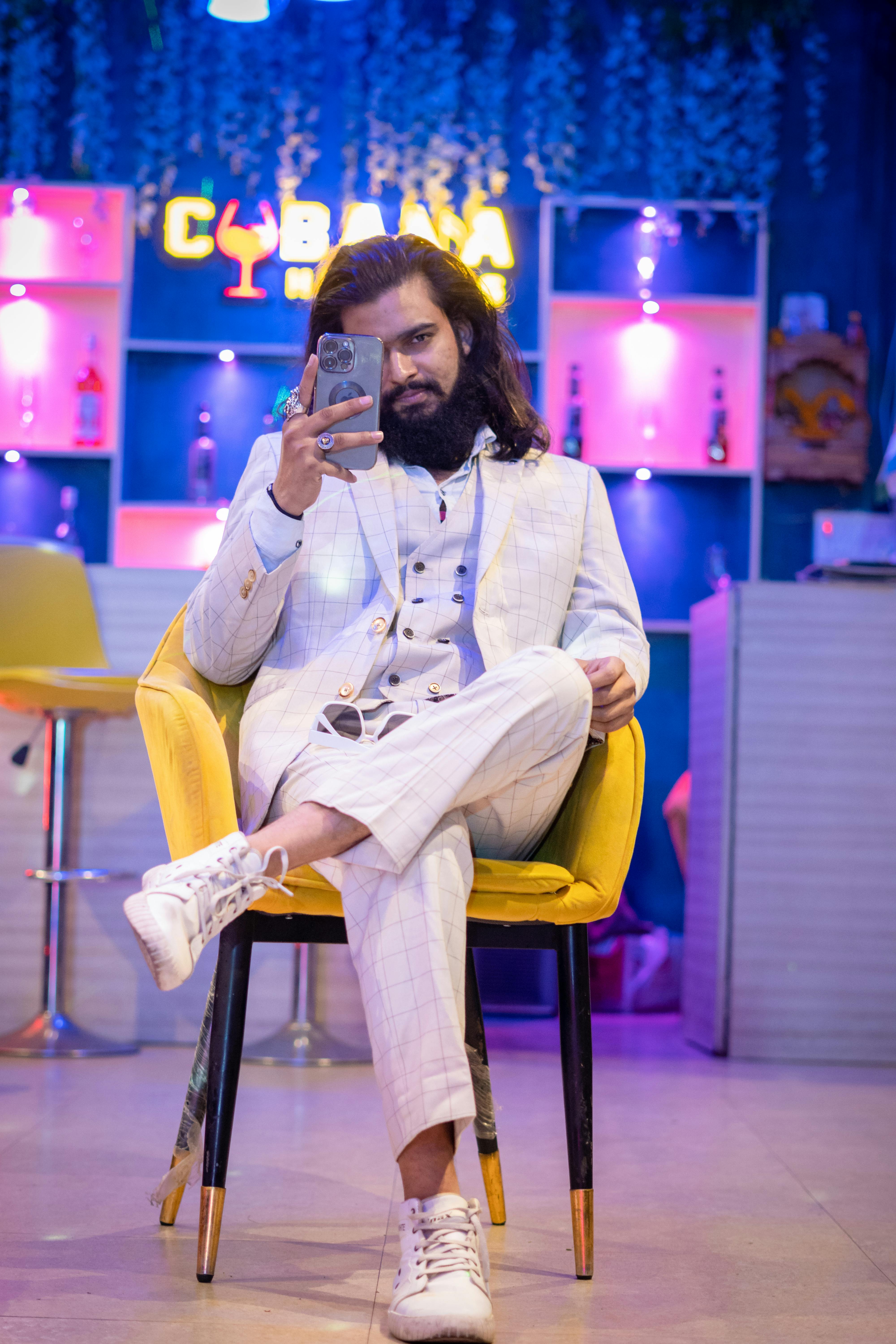 Stylish Man Posing in Vibrant Night Club Setting · Free Stock Photo