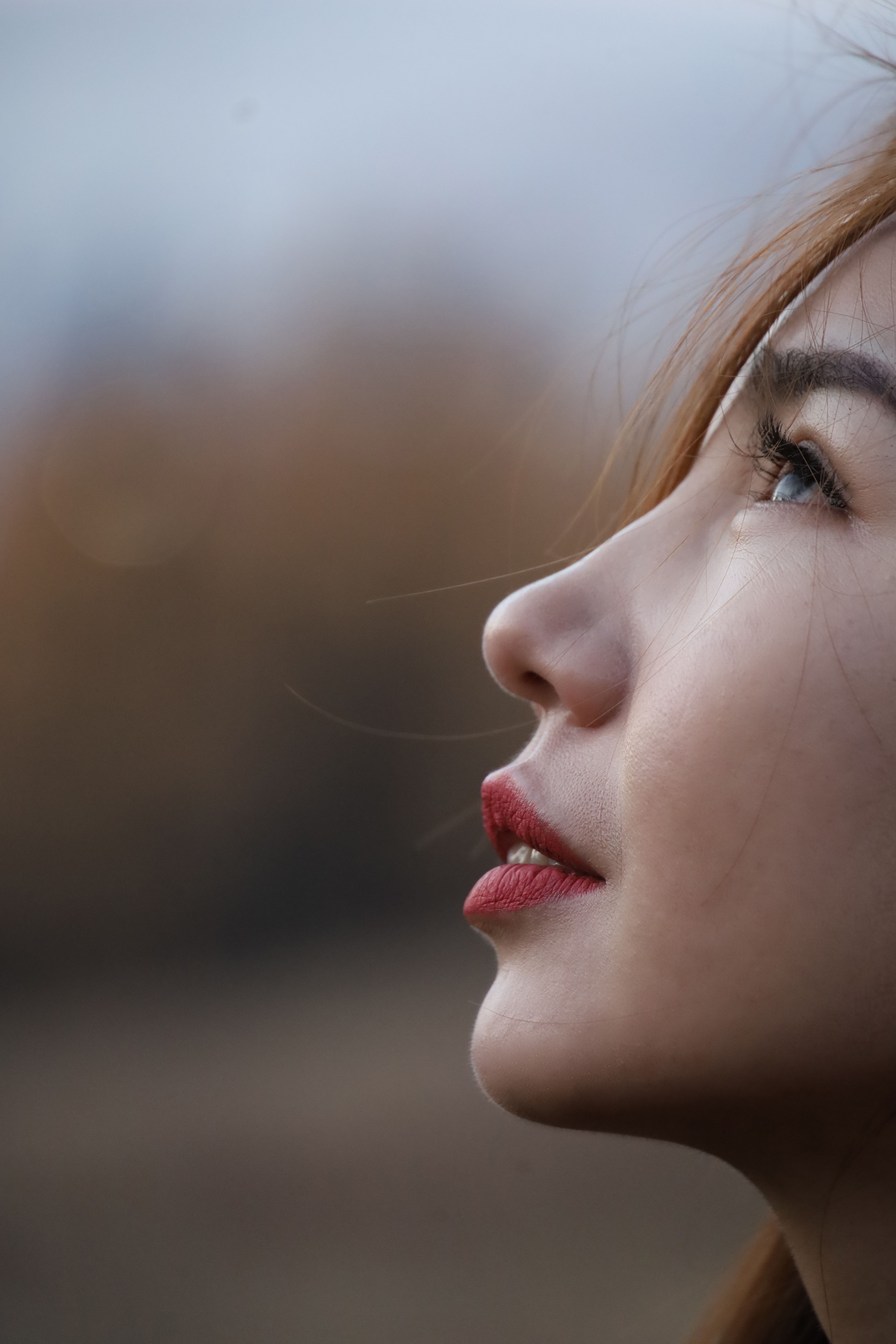 Close-up Portrait of Woman Looking Upwards Outdoors · Free Stock Photo