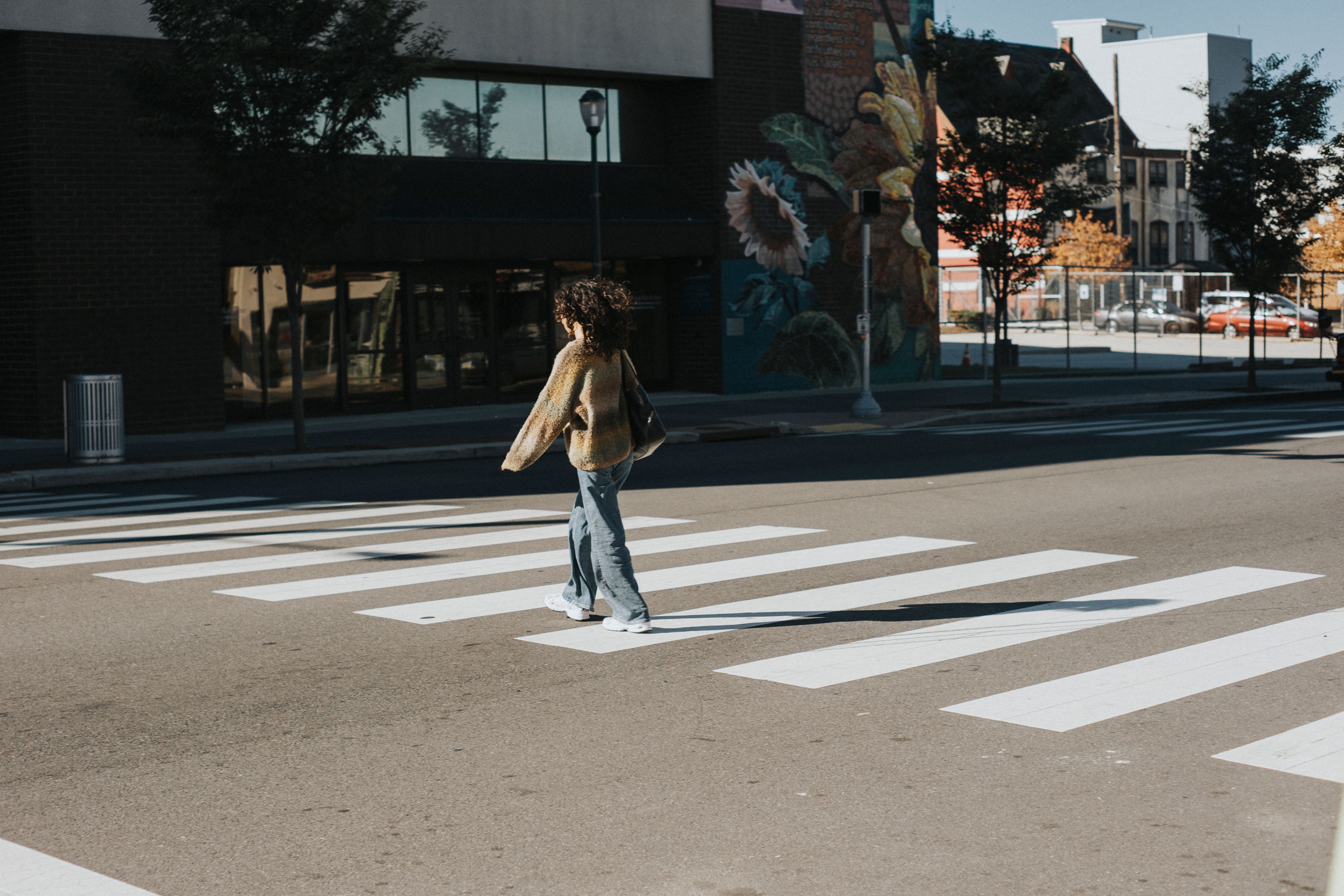 Woman Crossing Urban Street in Daylight · Free Stock Photo