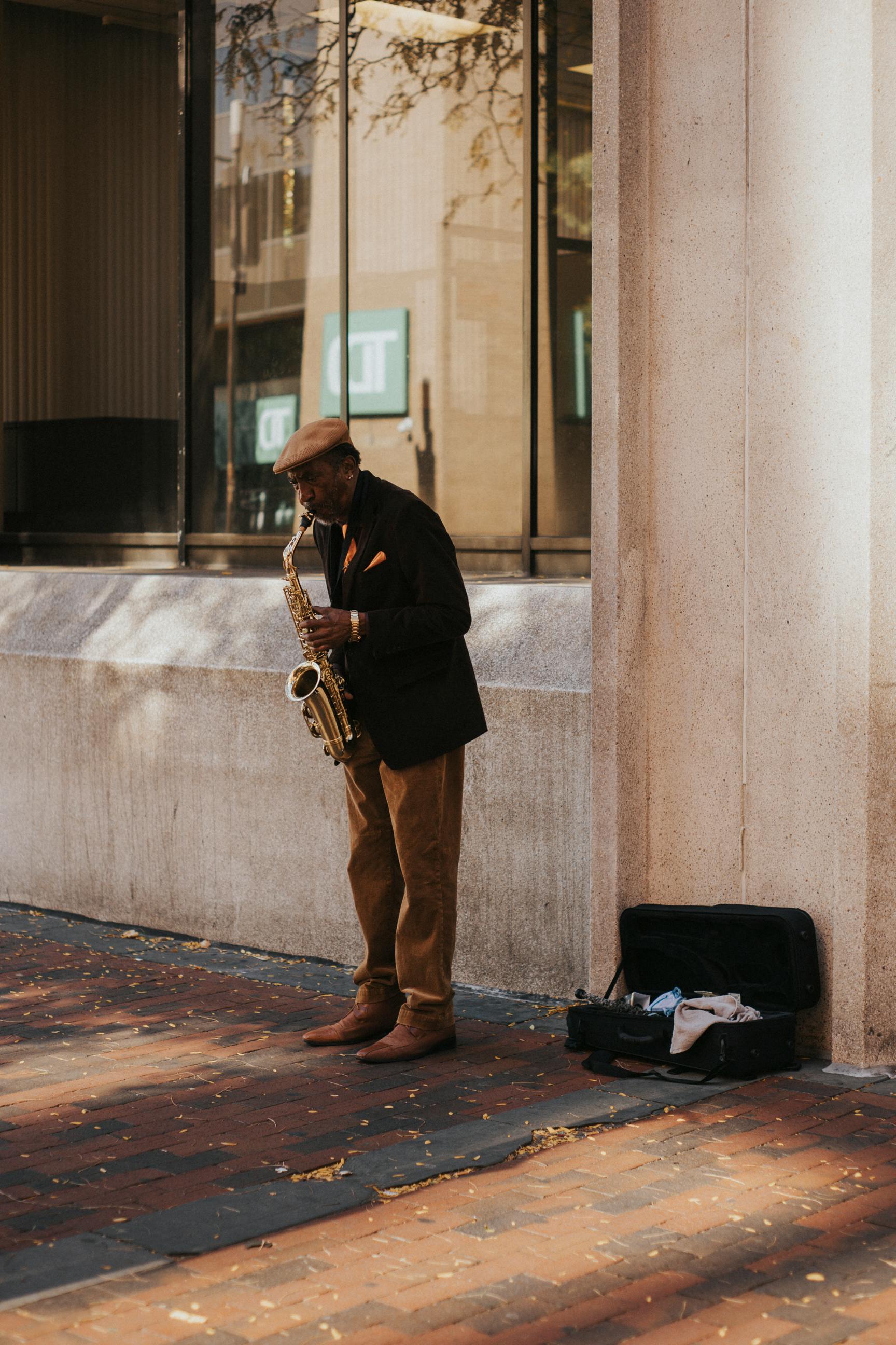 Street Musician Playing Saxophone in Urban Setting · Free Stock Photo