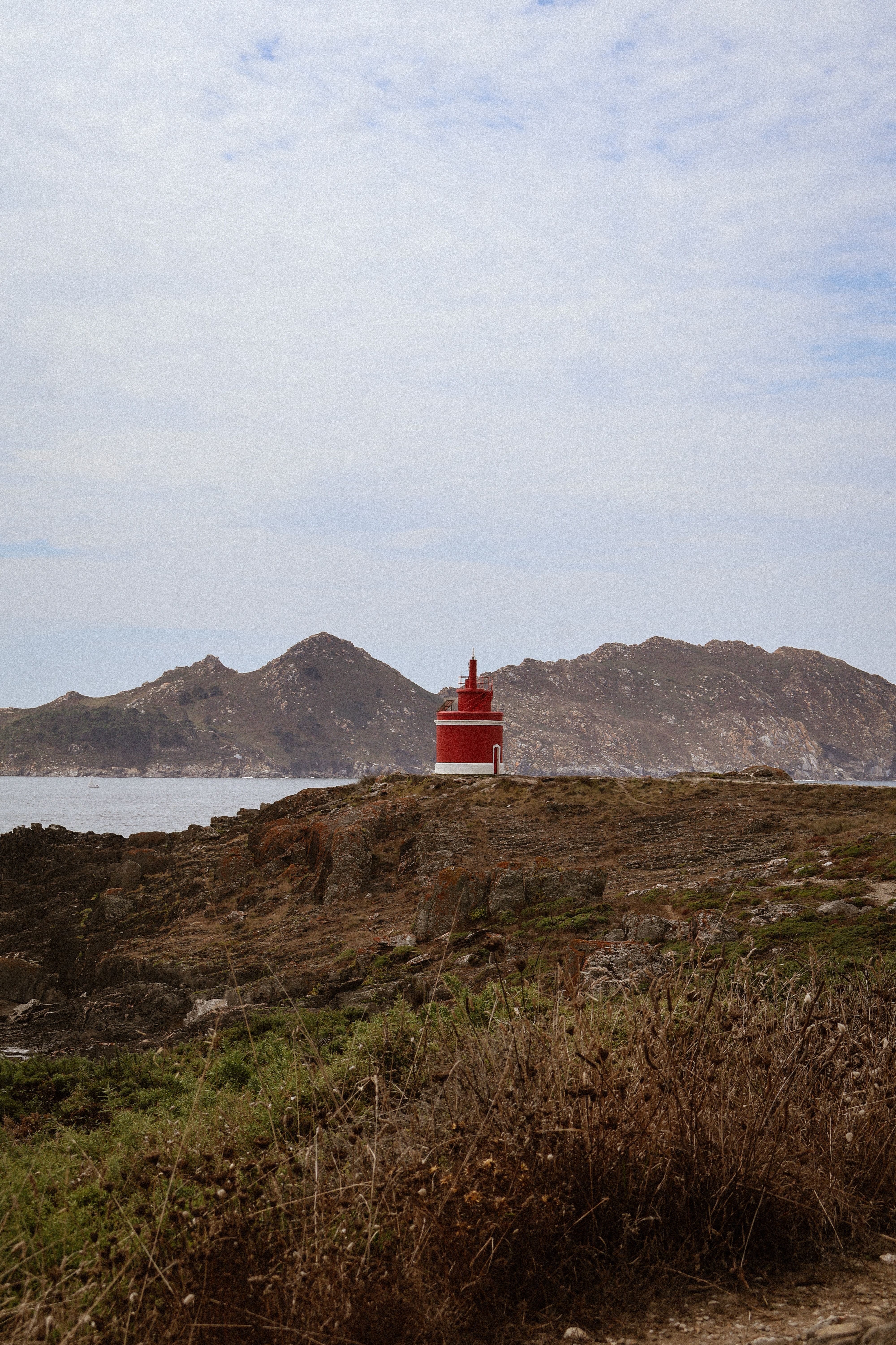 Faro Rojo En La Península Rocosa Bajo Un Cielo Azul · Foto de stock ...