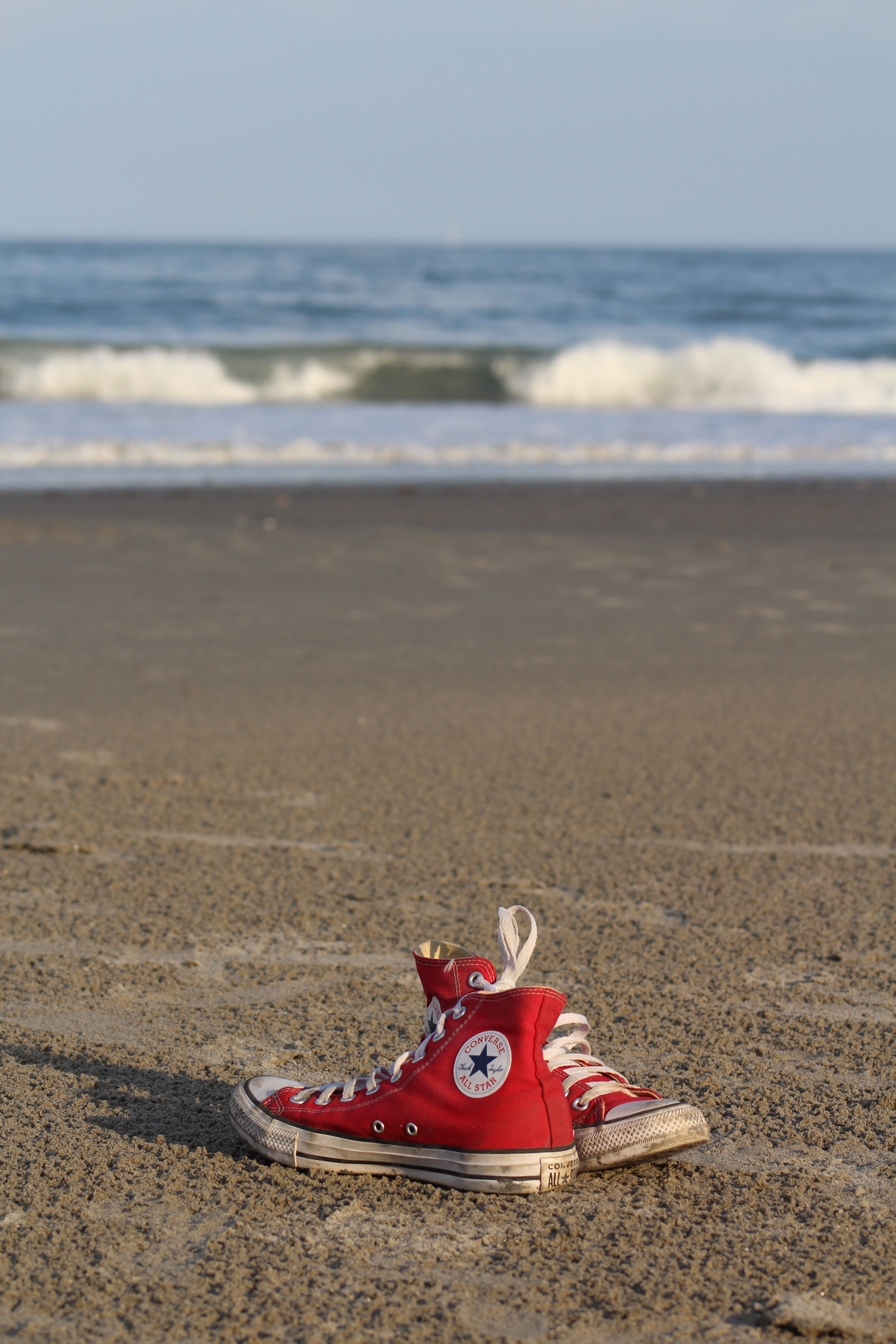 Red Converse Sneakers on a Sandy Beach Shore · Free Stock Photo