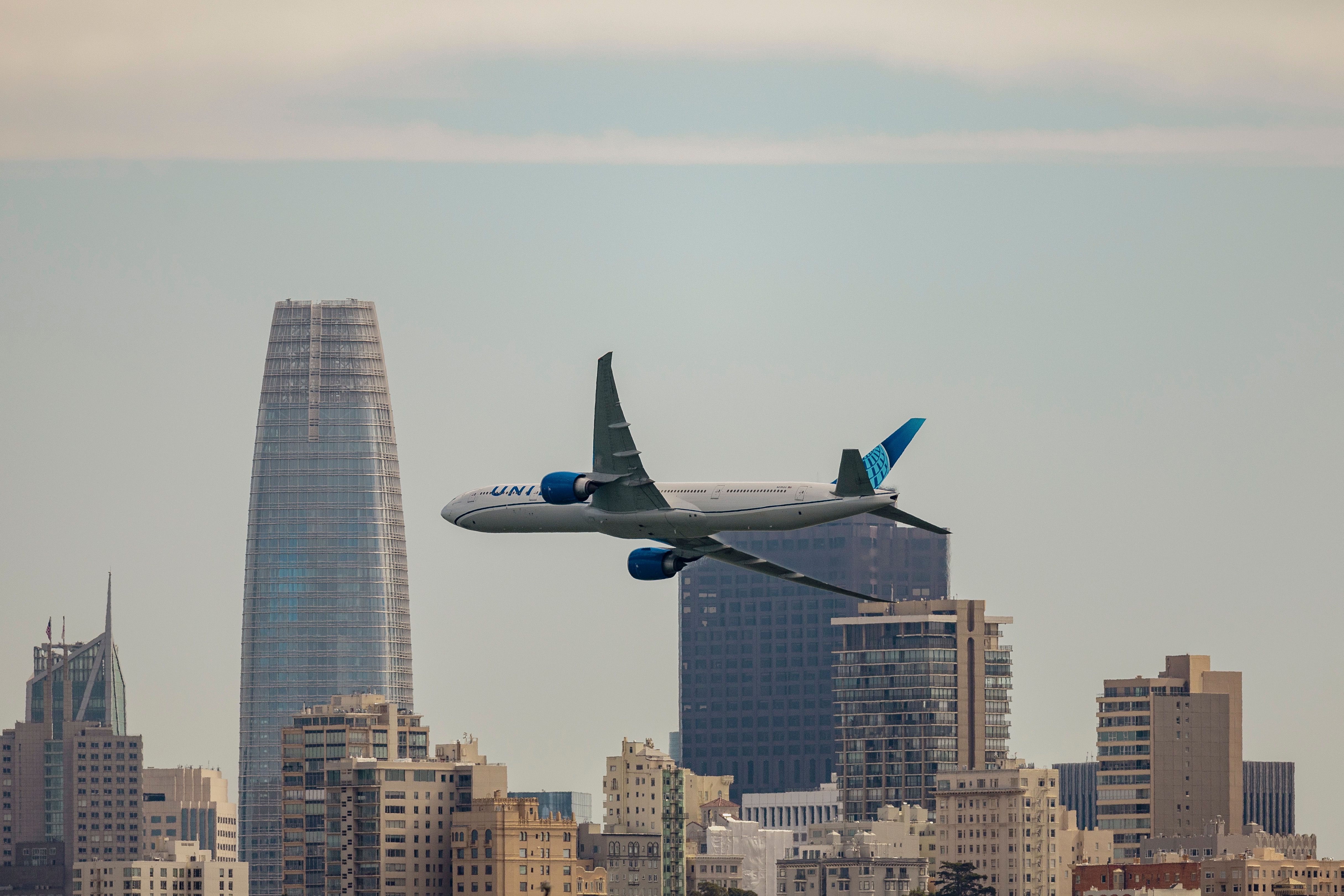 Airplane flying over San Francisco skyline · Free Stock Photo