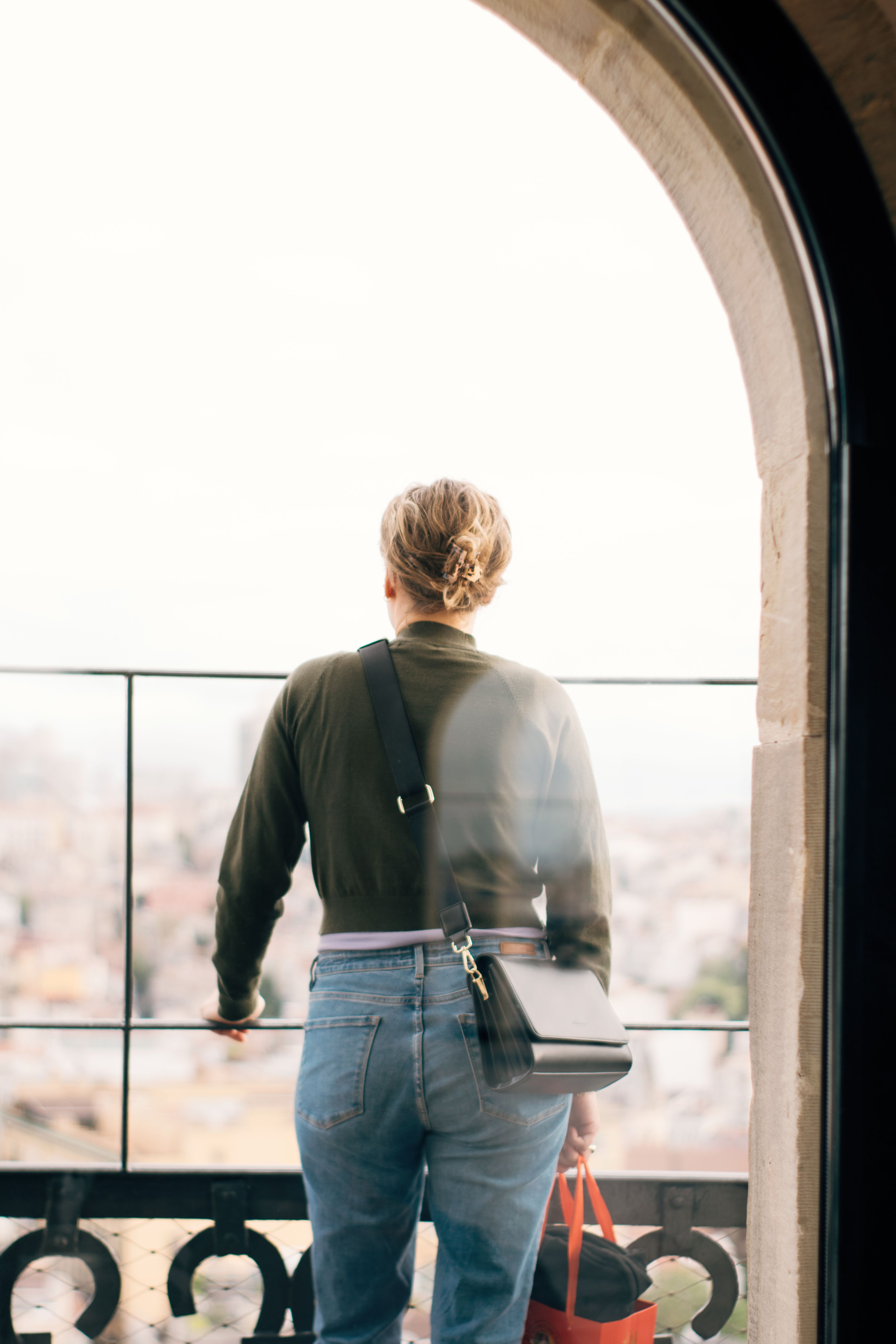 Woman Gazing From Balcony Over Cityscape · Free Stock Photo