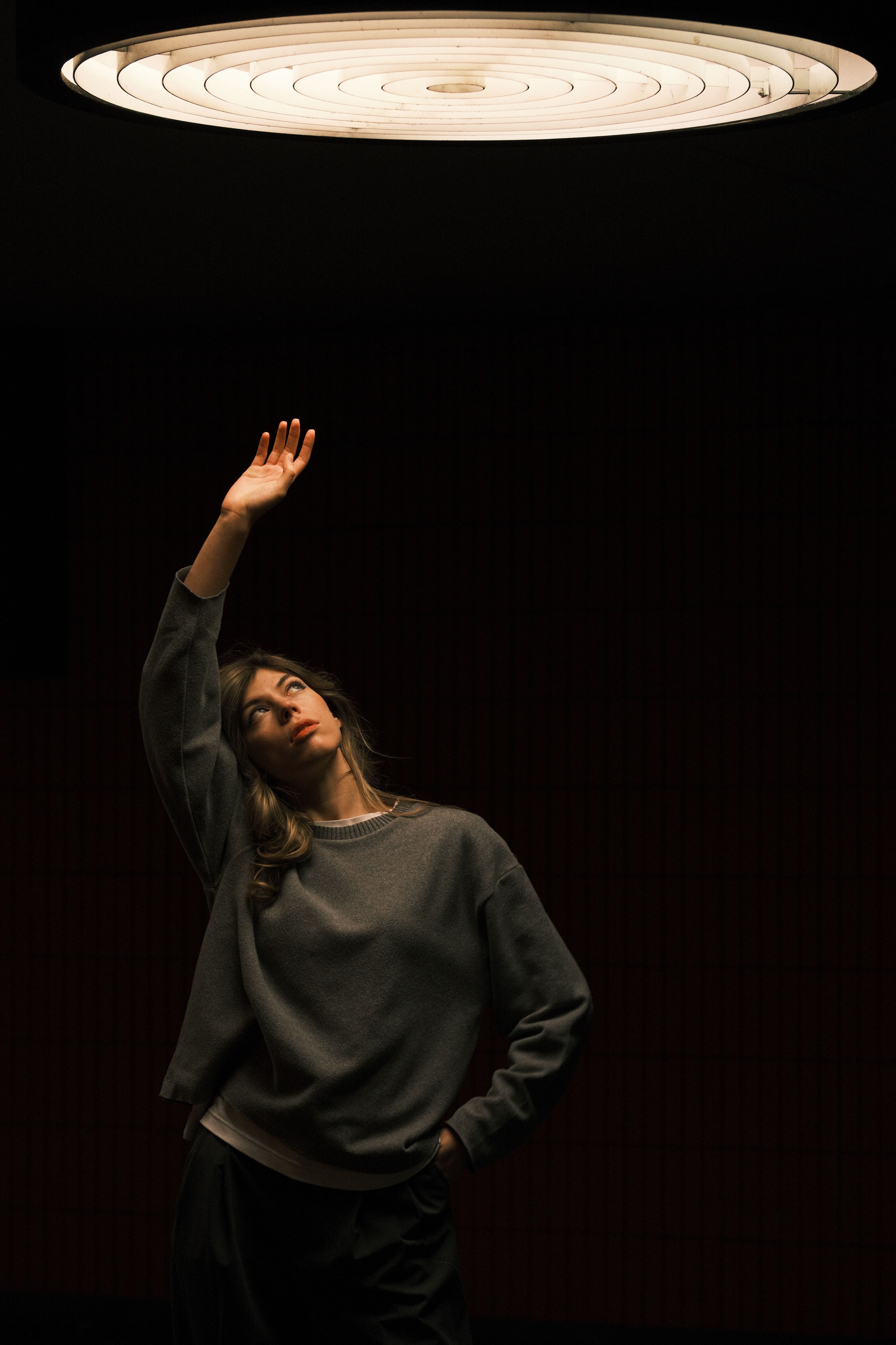 Woman Reaching Towards Circular Ceiling Light · Free Stock Photo