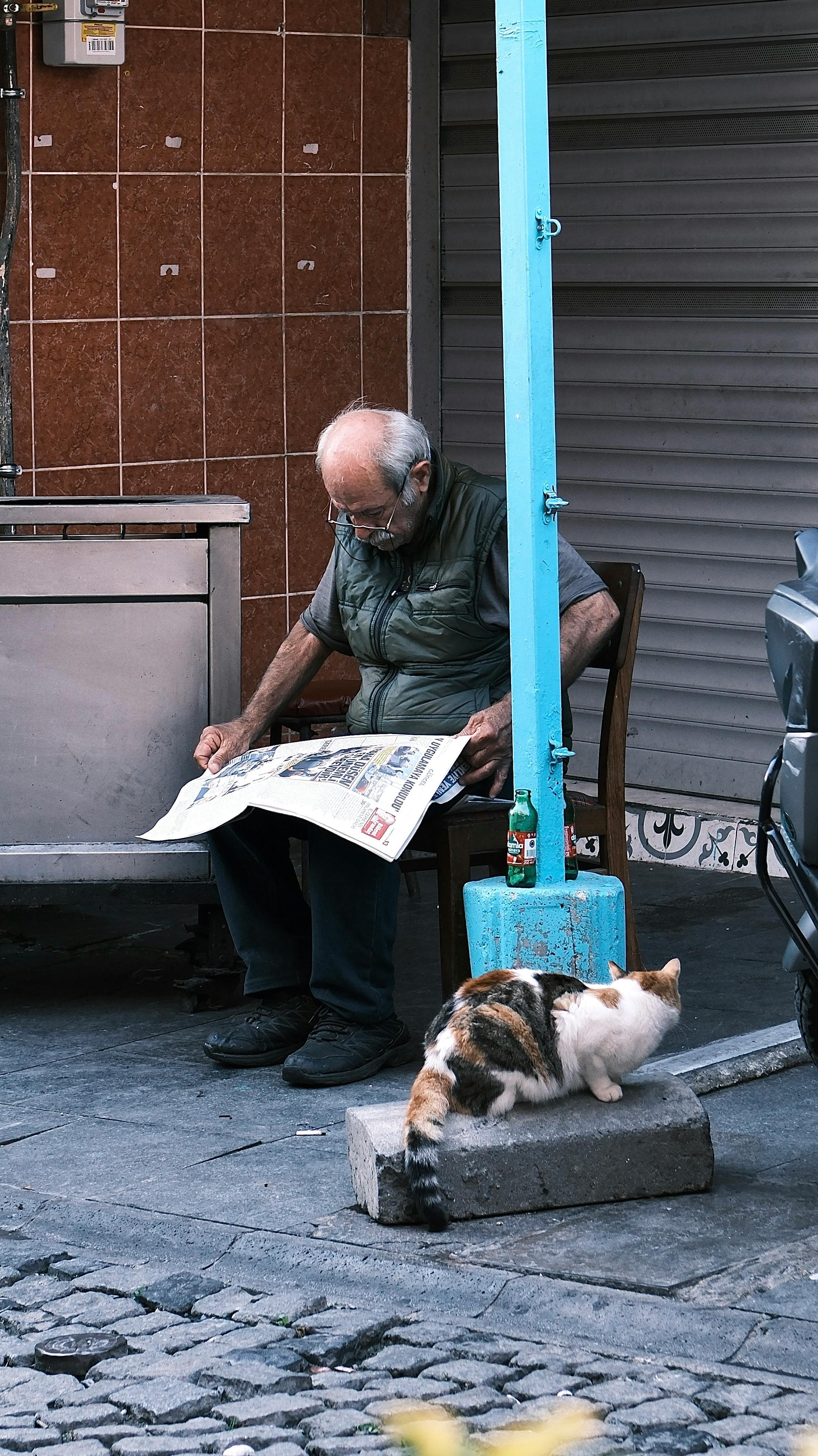 Elderly Man Reading Newspaper on Street Corner · Free Stock Photo