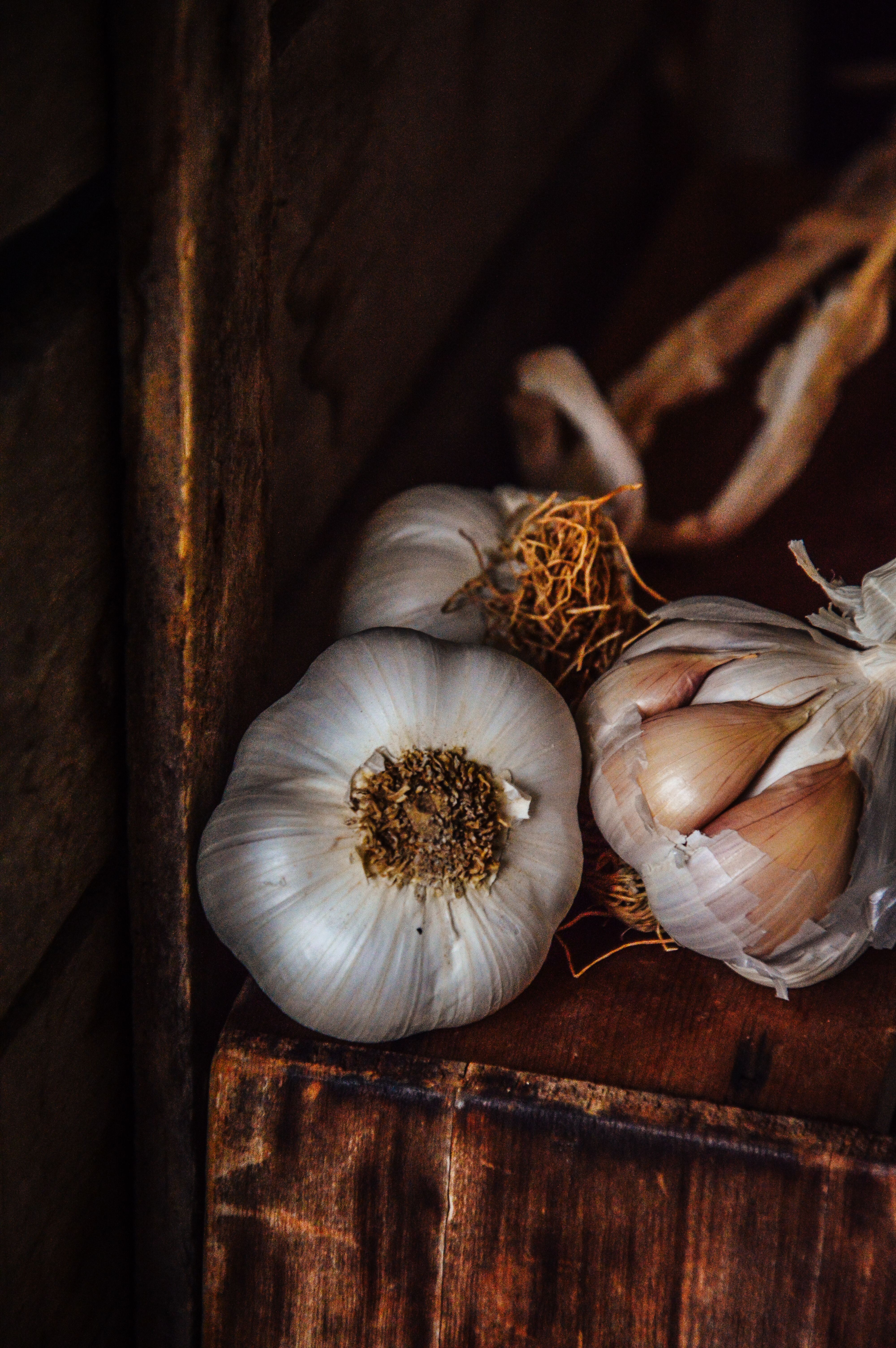 Close-up of Fresh Organic Garlic Bulbs on Rustic Surface · Free Stock Photo