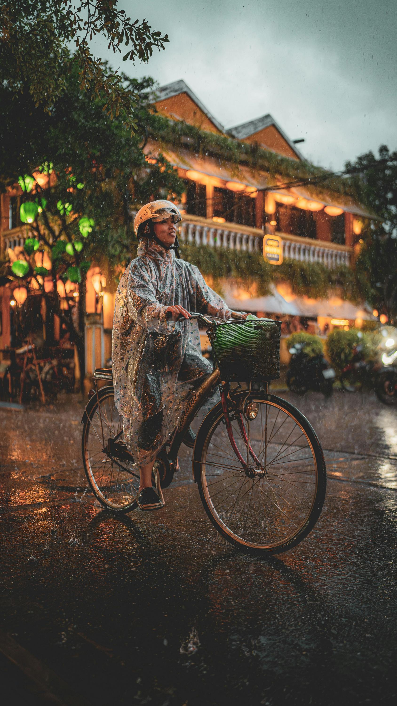 Cyclist in Rain with Traditional Building at Night · Free Stock Photo
