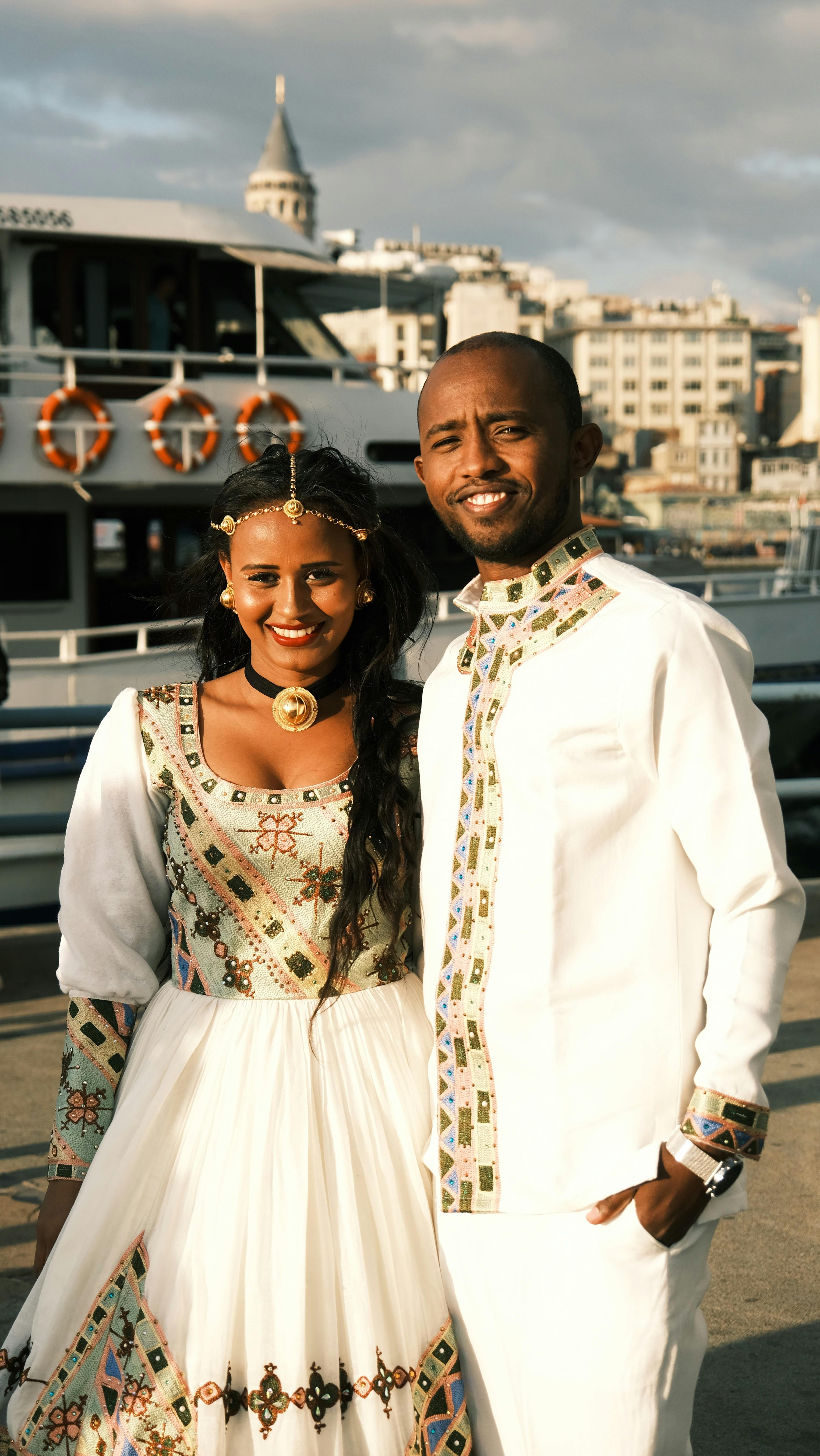 Couple in Traditional Attire by Waterfront · Free Stock Photo