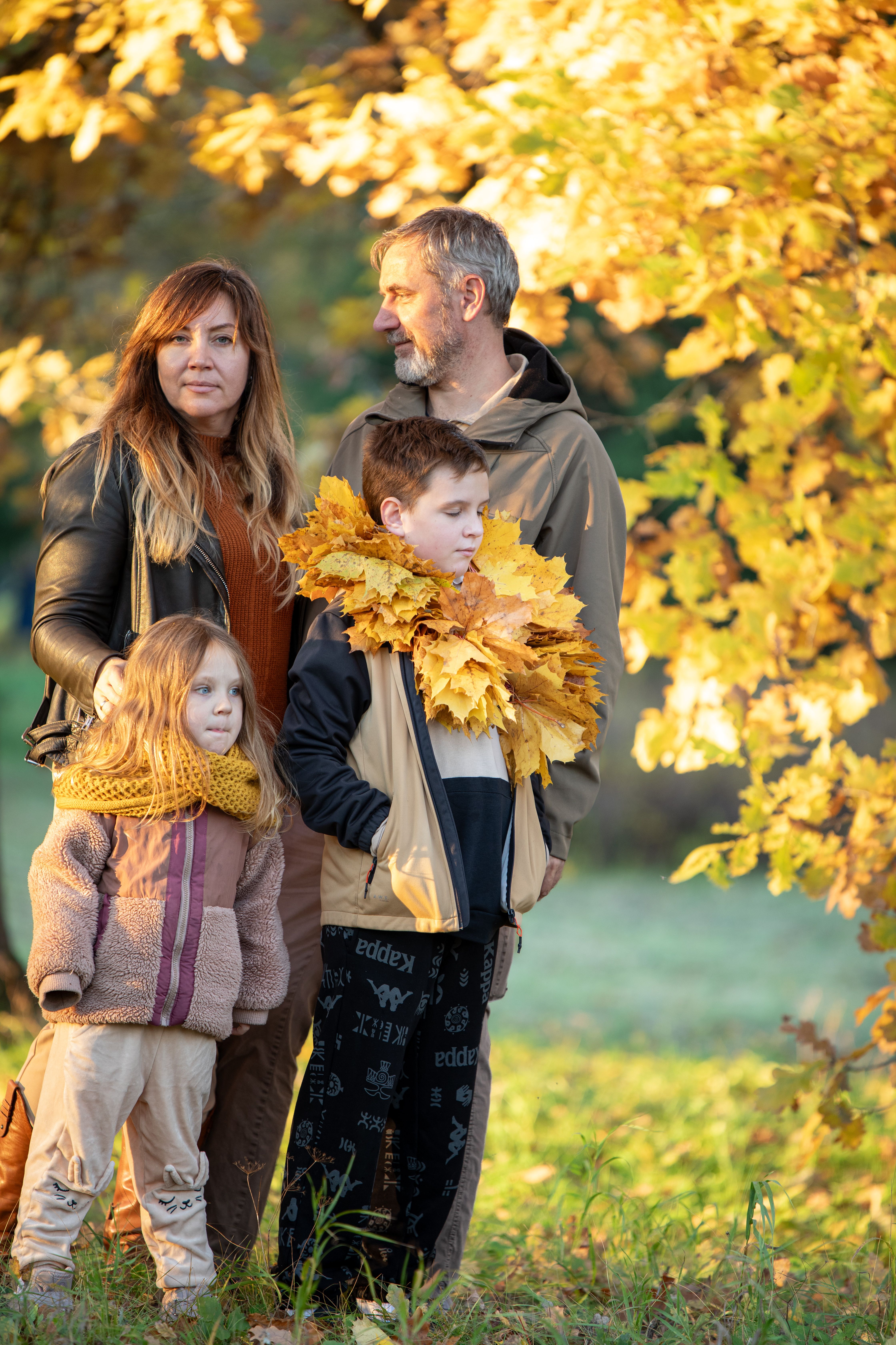 Family Embracing Autumn in a Golden Leafy Park · Free Stock Photo