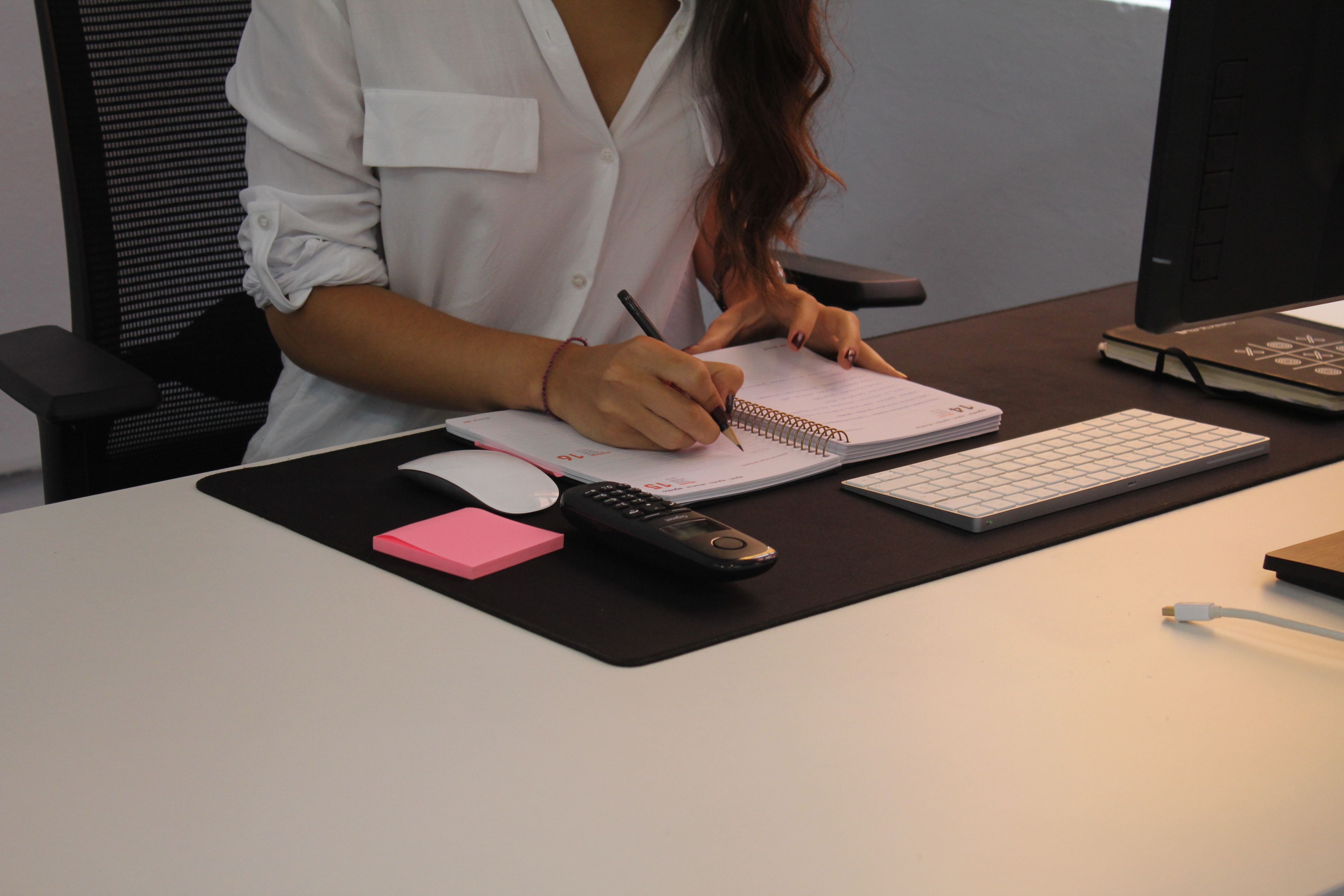 Professional Woman Working at Office Desk with Notebook · Free Stock Photo