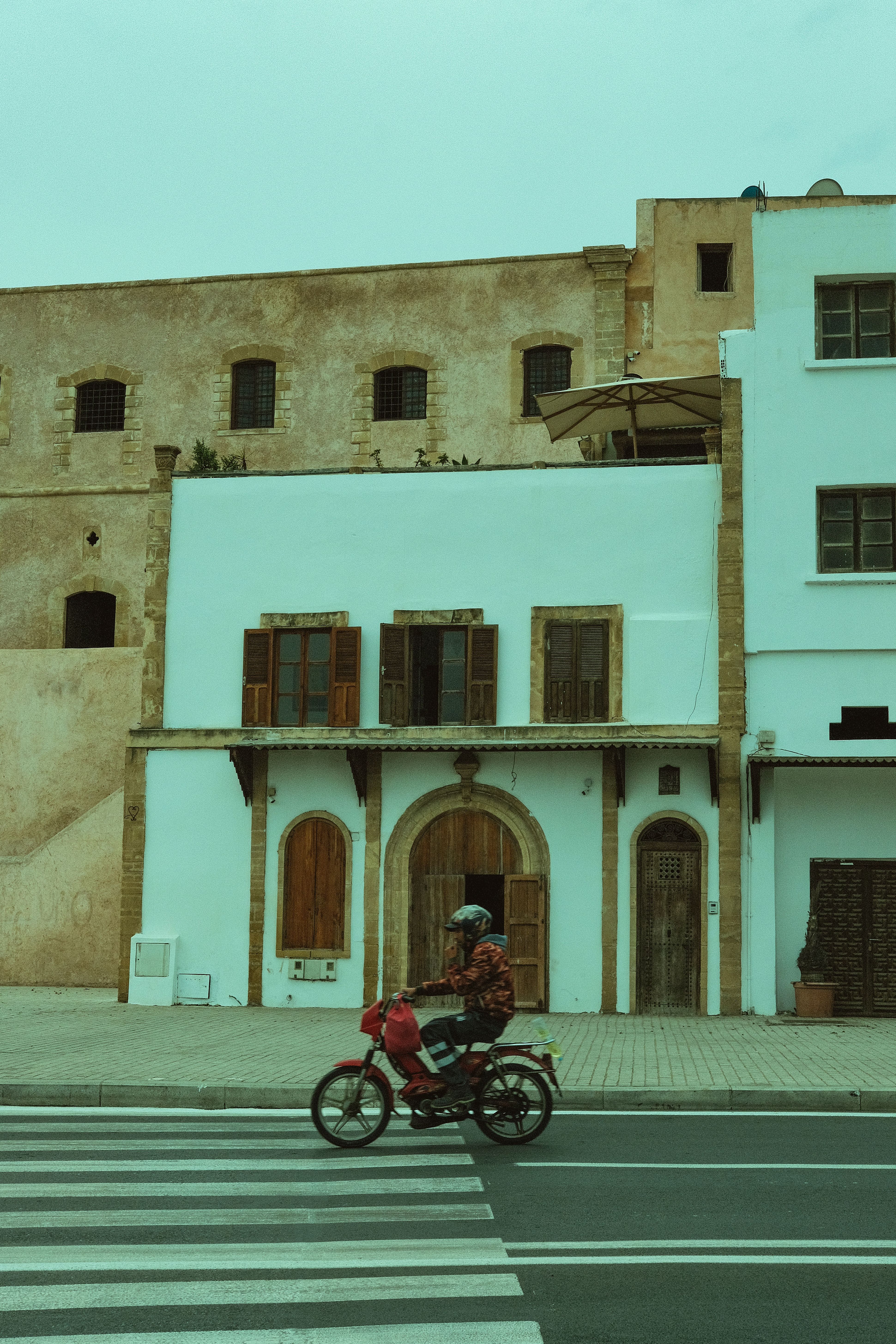 Motorcyclist Passing Historic Building · Free Stock Photo