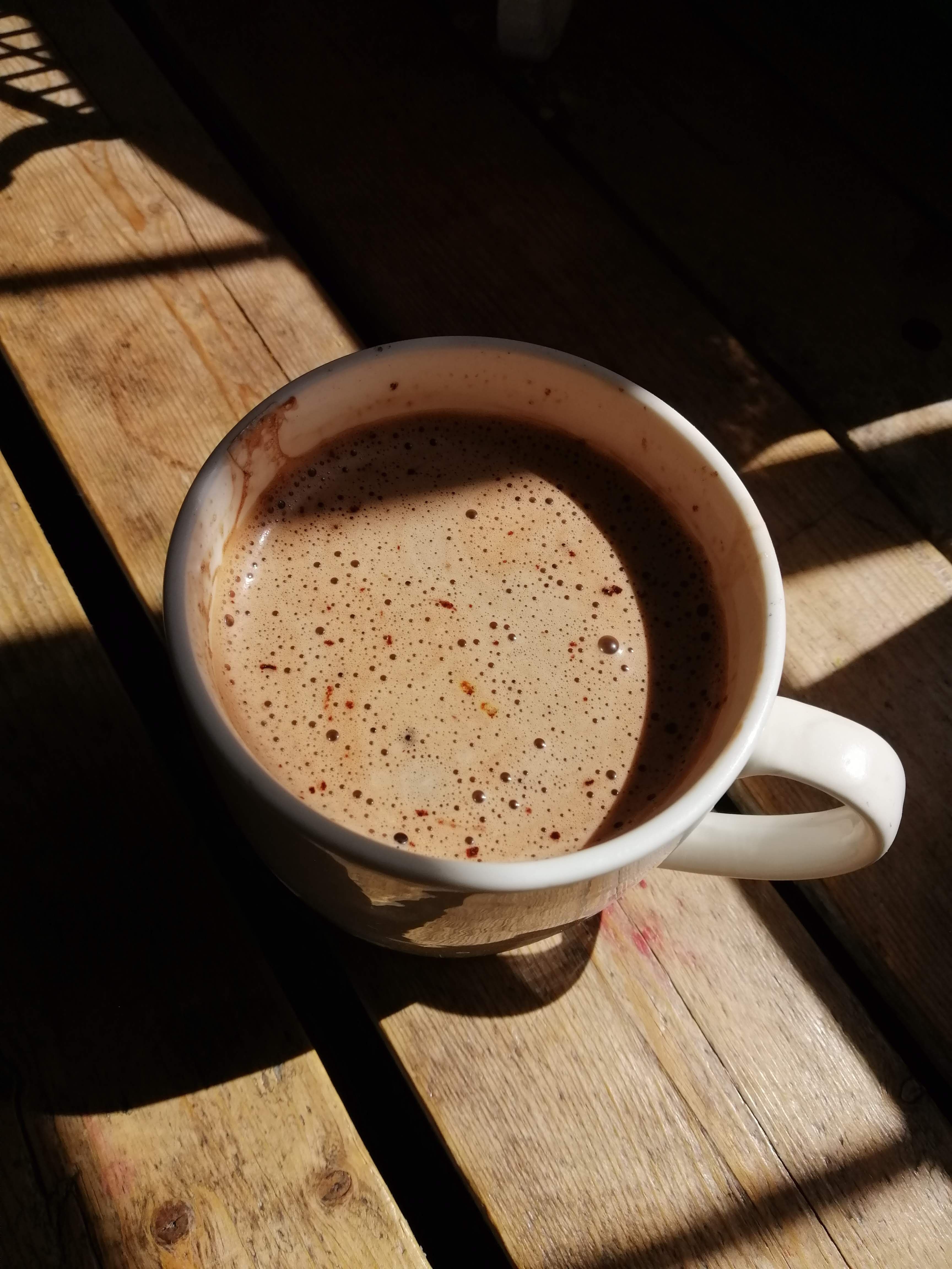 Warm Cup of Frothy Hot Chocolate on Wooden Table · Free Stock Photo