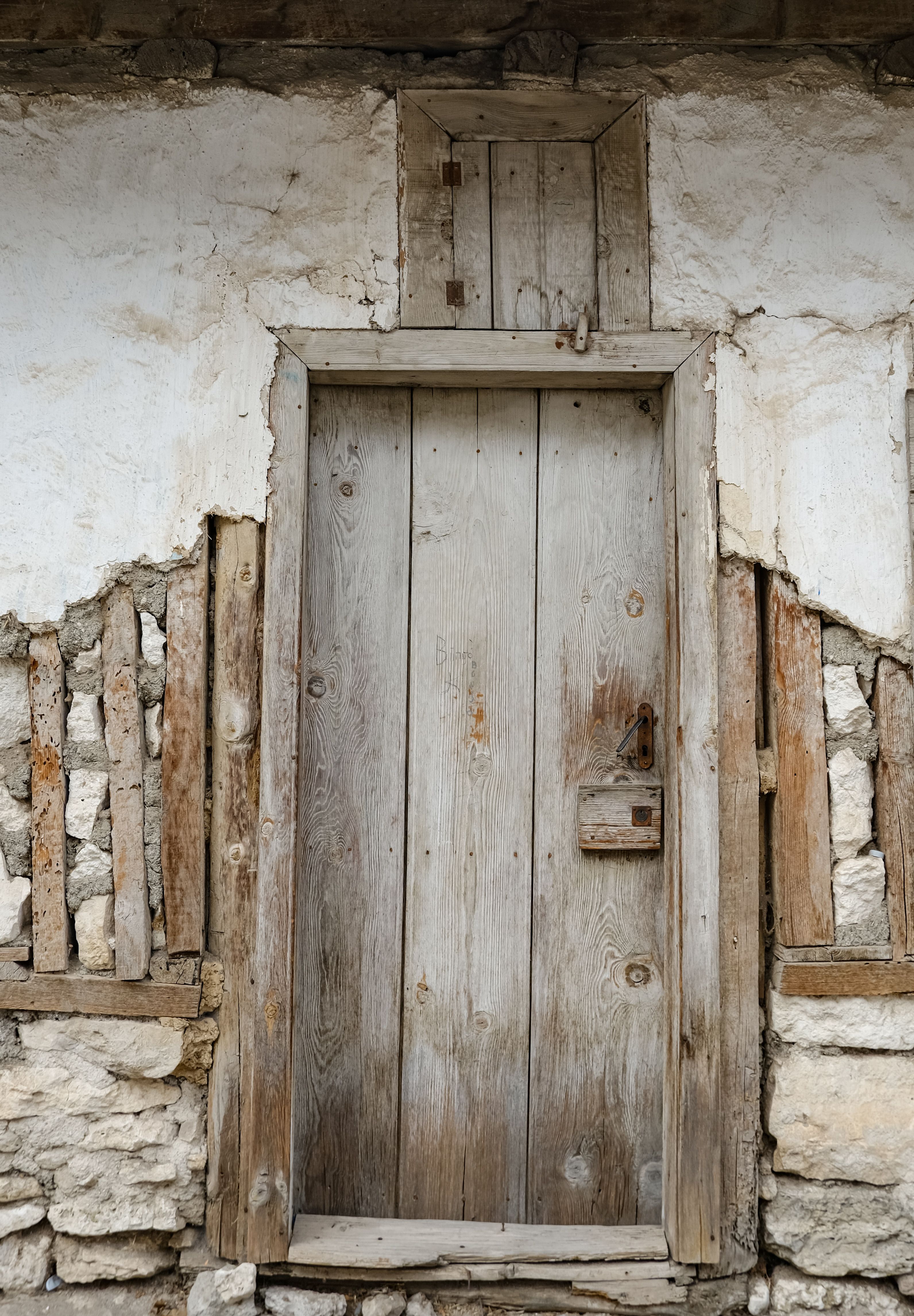 Rustic Wooden Door in Weathered Stone Wall · Free Stock Photo