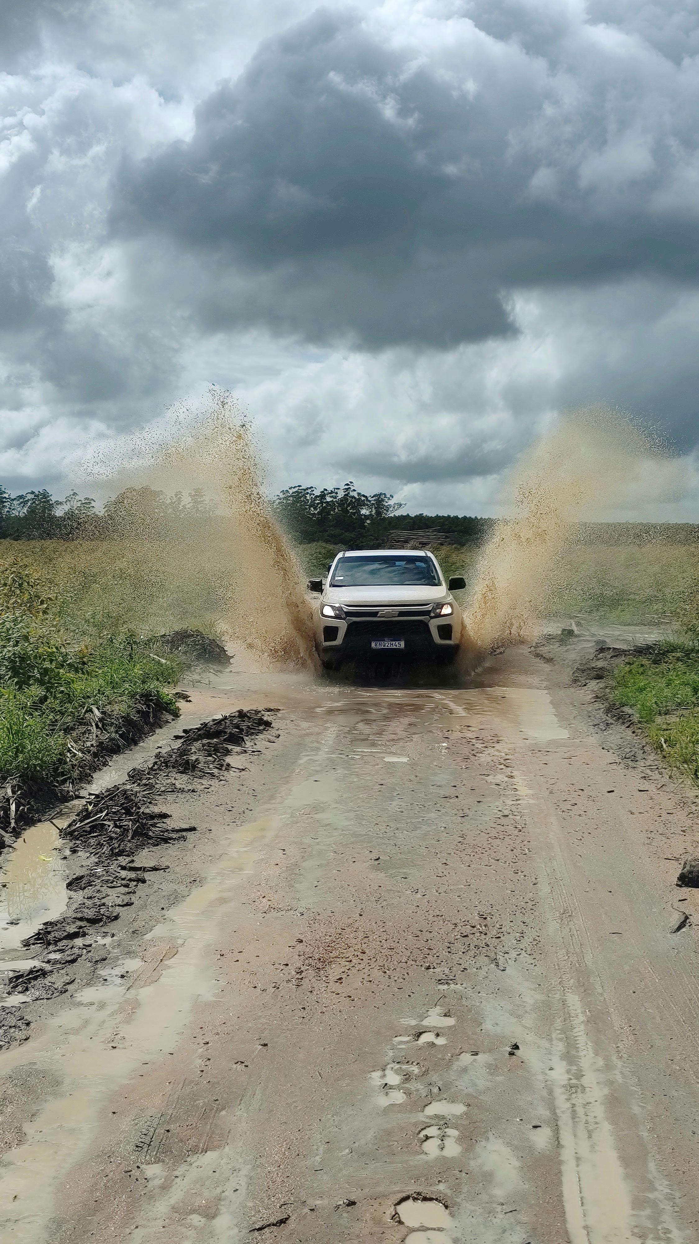 Off-road Adventure: SUV Splashing Through Muddy Road · Free Stock Photo