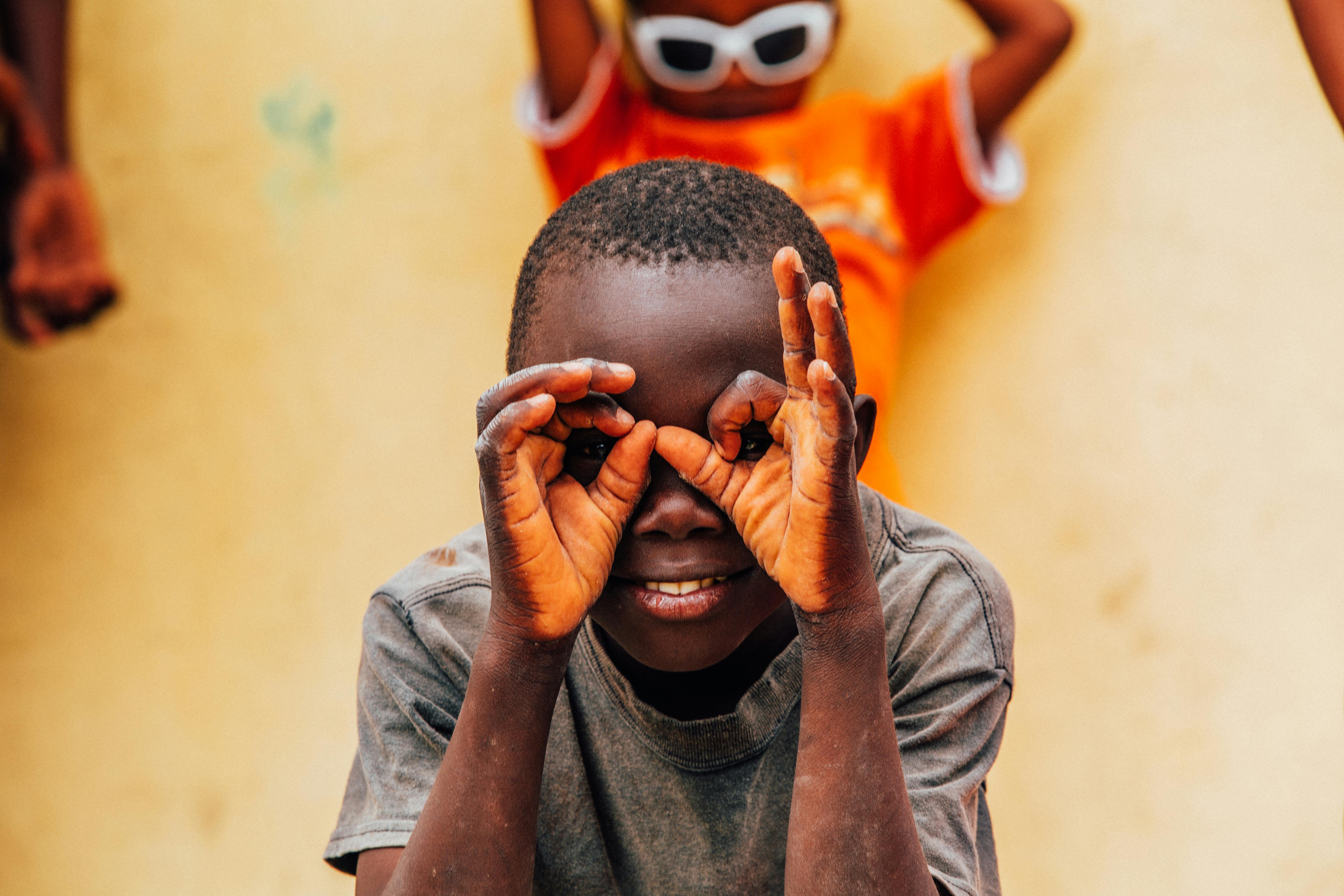 Photo of Boy Doing Hand Sign on His Face · Free Stock Photo