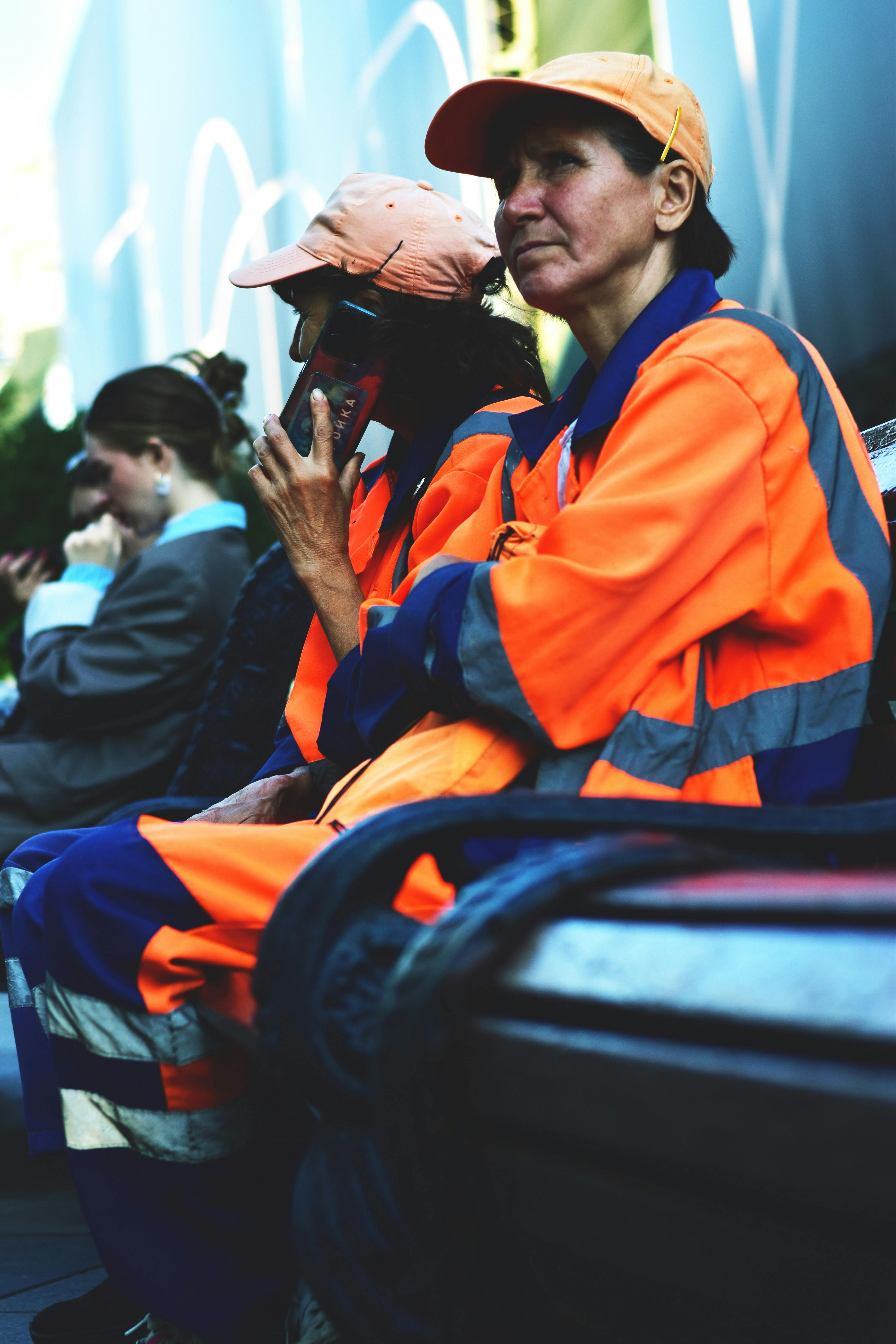Urban Workers Relaxing on a Break in Bright Uniforms · Free Stock Photo