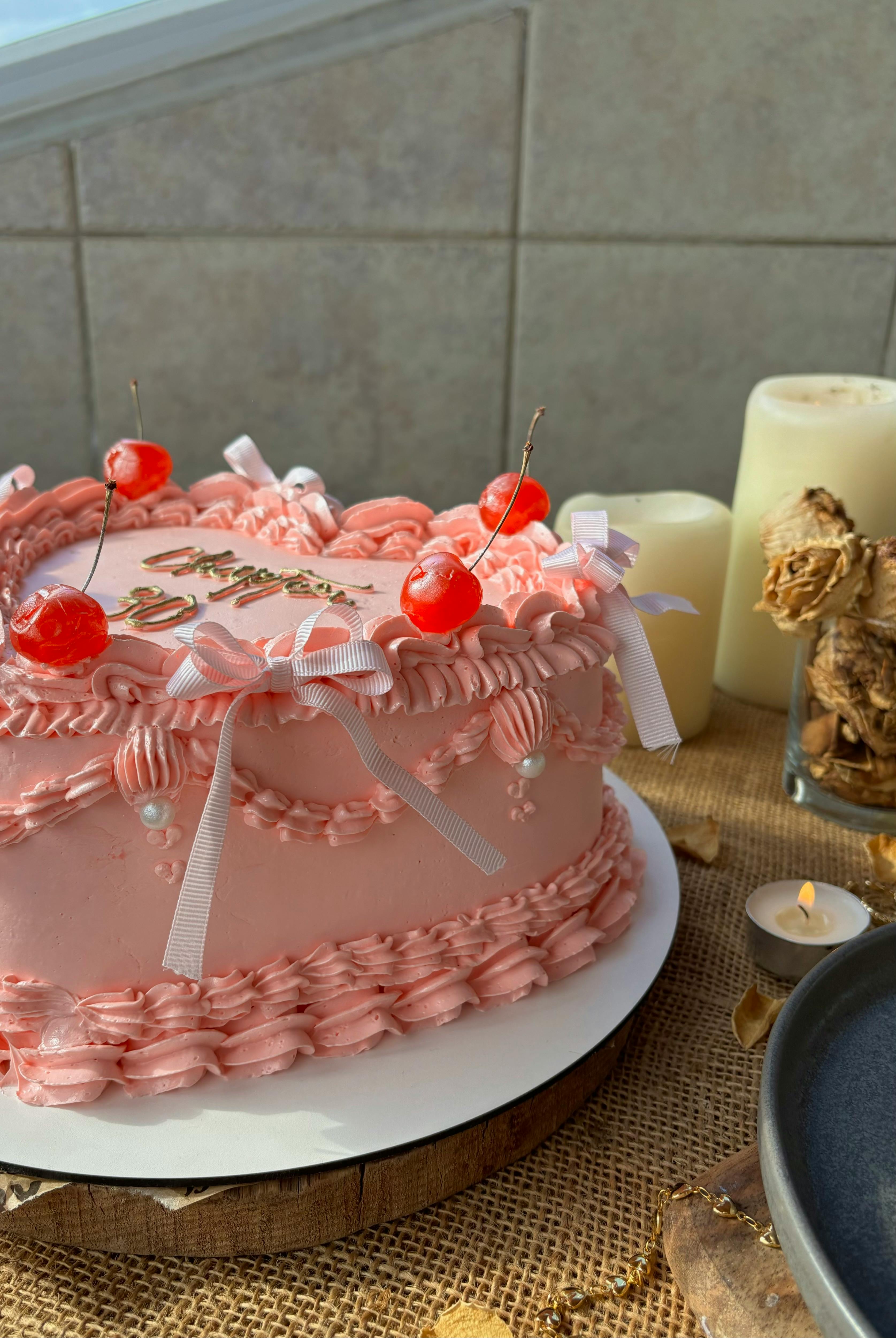 Elegant Pink Cake with Cherry Garnish and Candles · Free Stock Photo